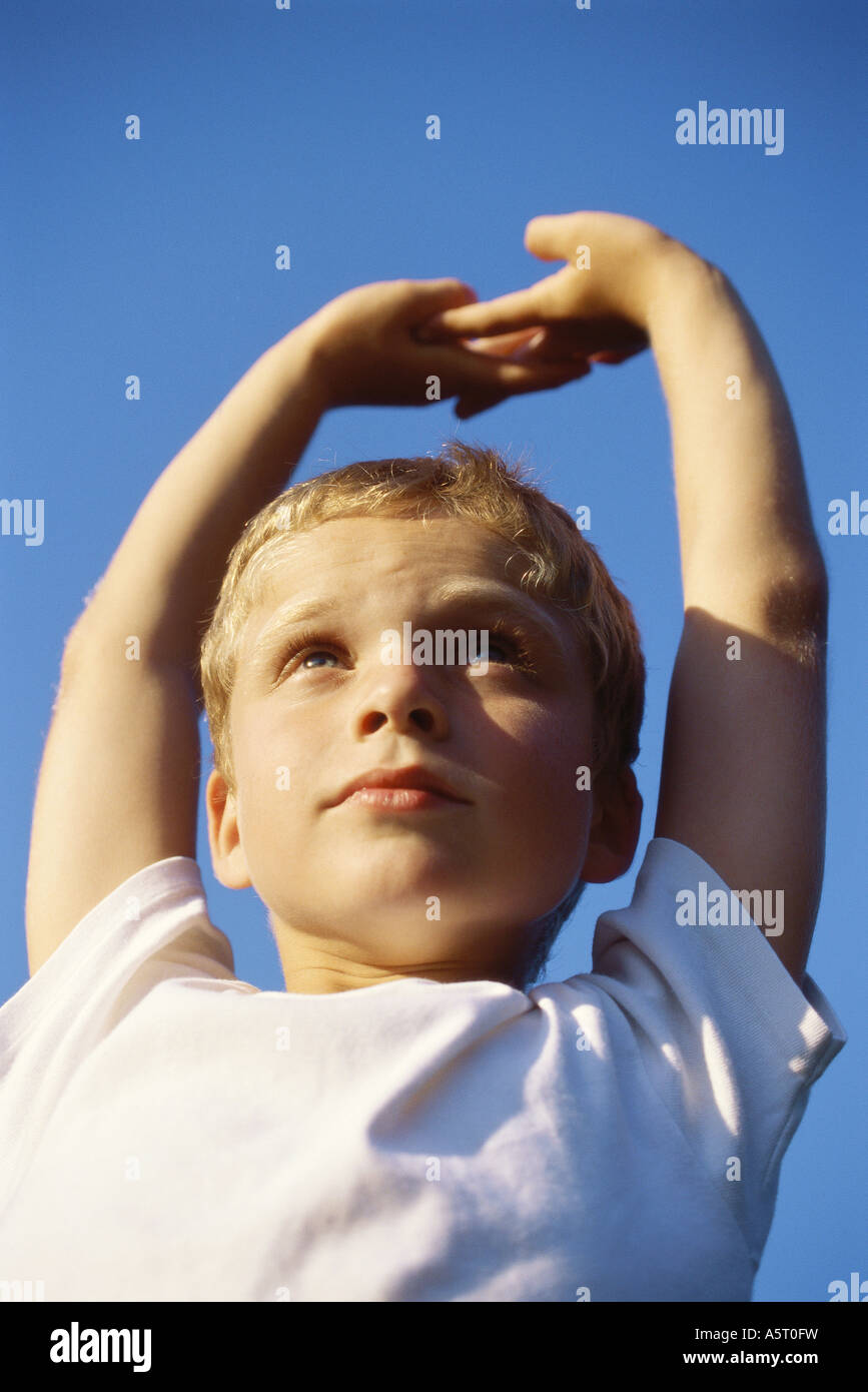 Boy stretching arms above head Stock Photo - Alamy