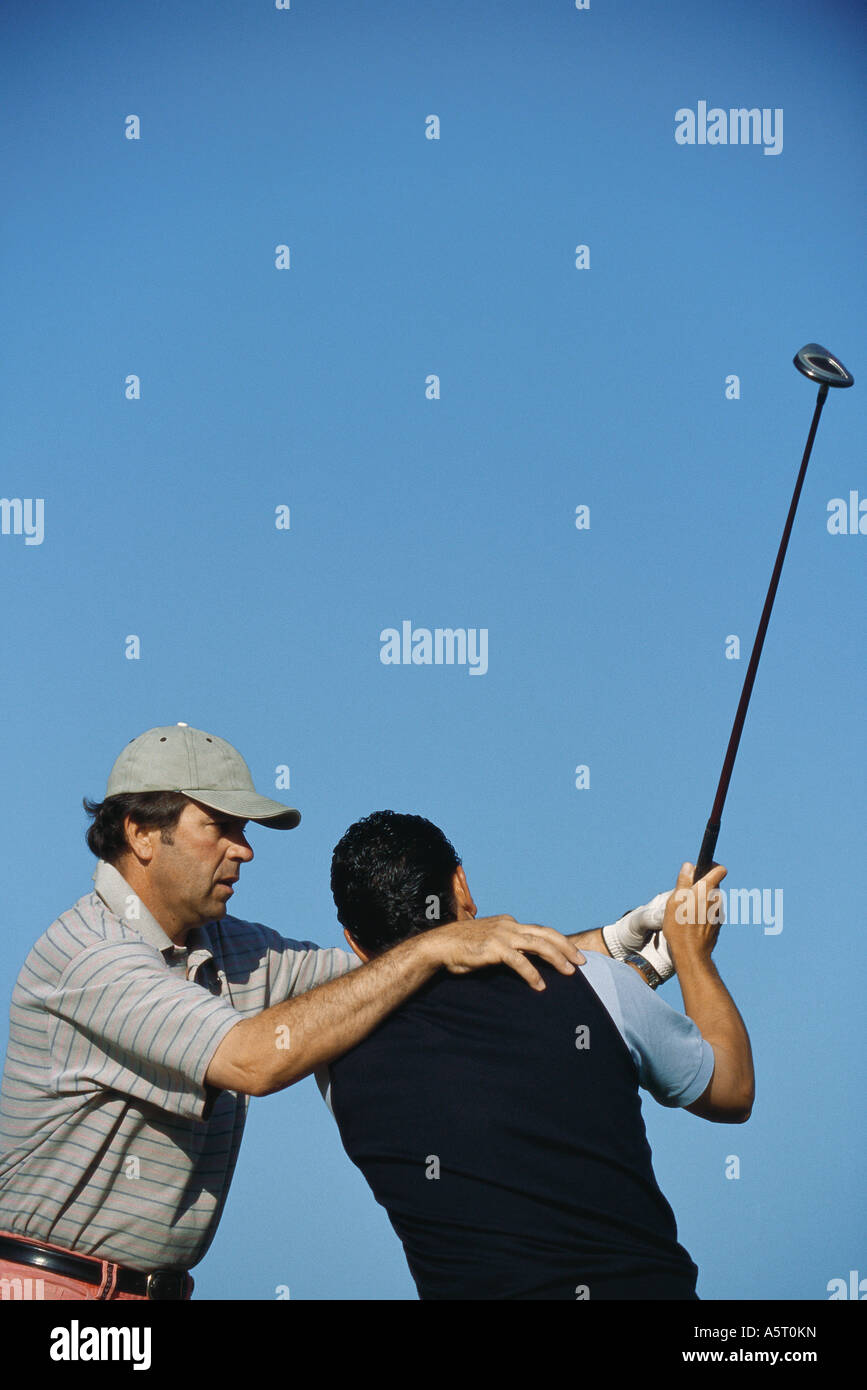 Golf instructor positioning client Stock Photo - Alamy