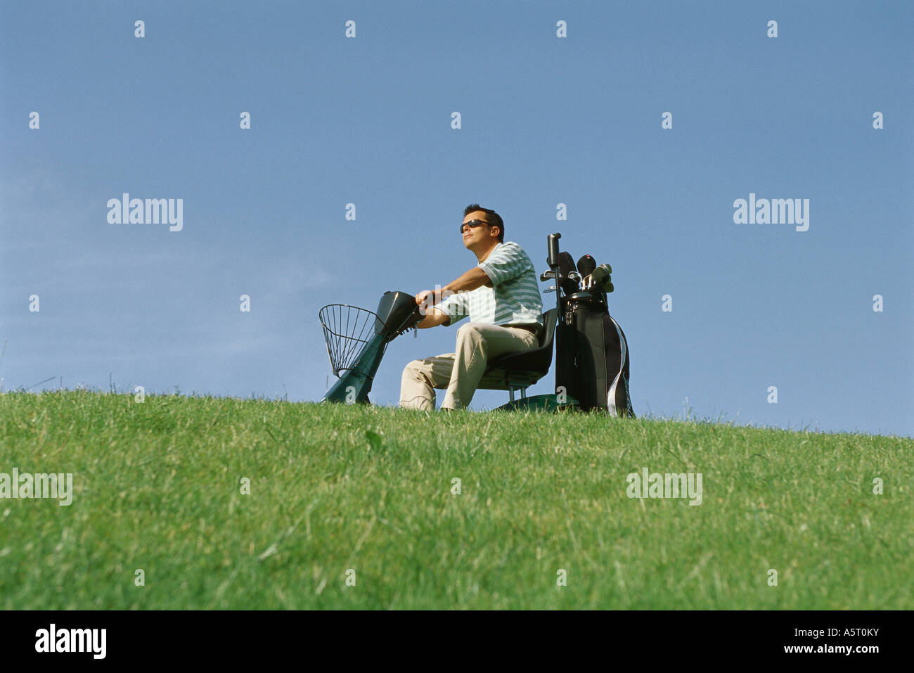 Golfer driving electric golf caddy Stock Photo - Alamy