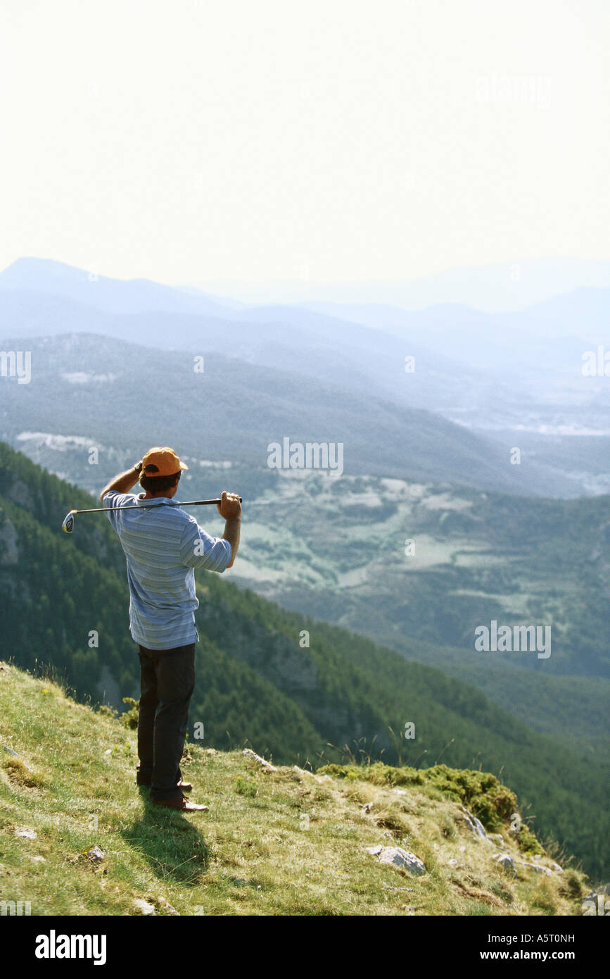 Golfer standing, overlooking mountainous landscape Stock Photo - Alamy