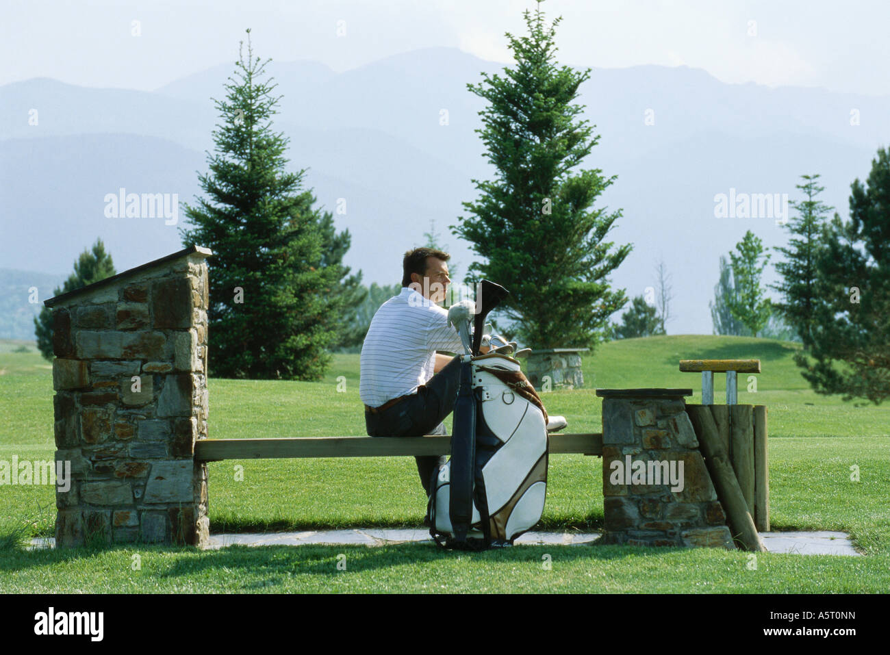 Golfer sitting on bench Stock Photo - Alamy