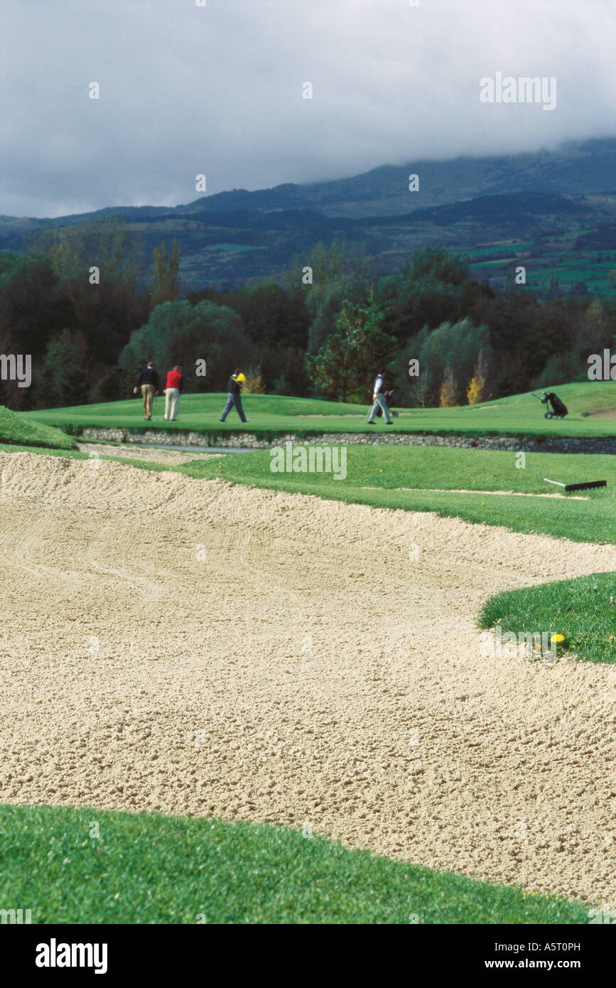 Golfers on golf course, sand trap in foreground Stock Photo - Alamy
