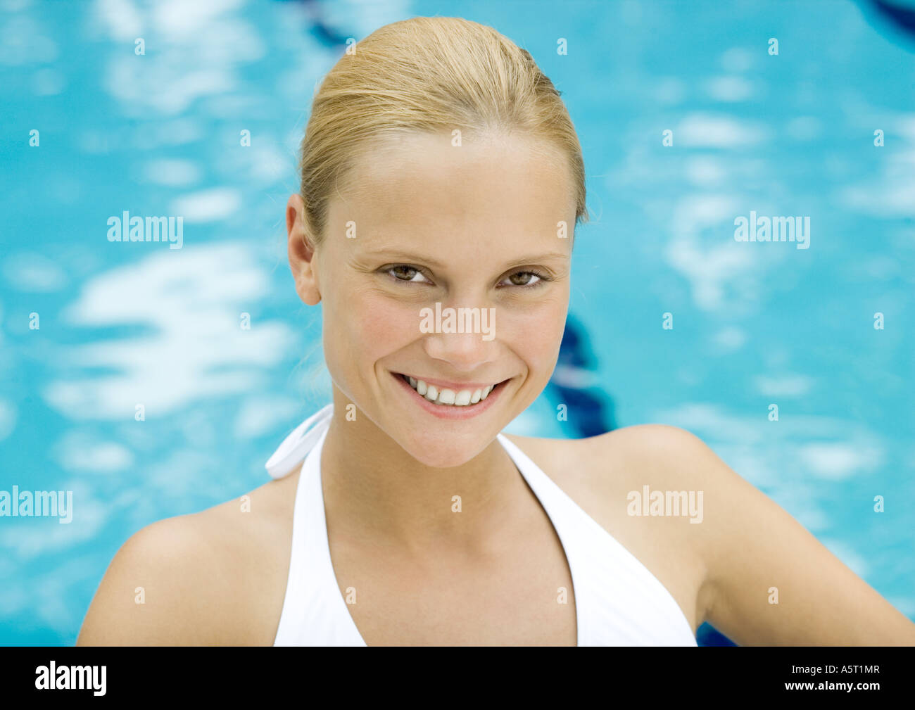 Young woman smiling, portrait, pool in background Stock Photo - Alamy