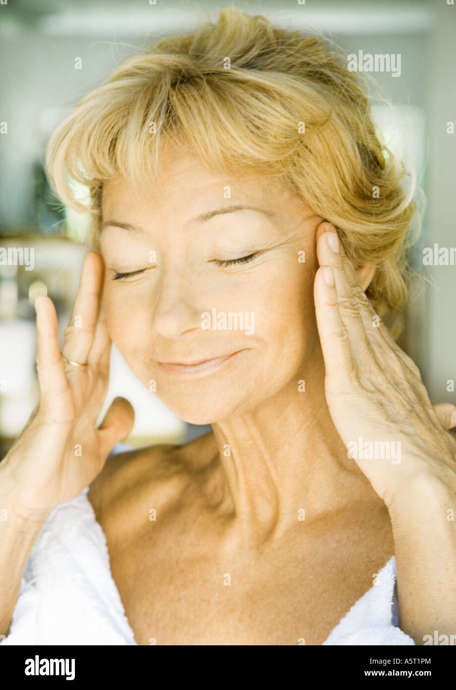Senior woman with hands on side of face and eyes shut Stock Photo - Alamy