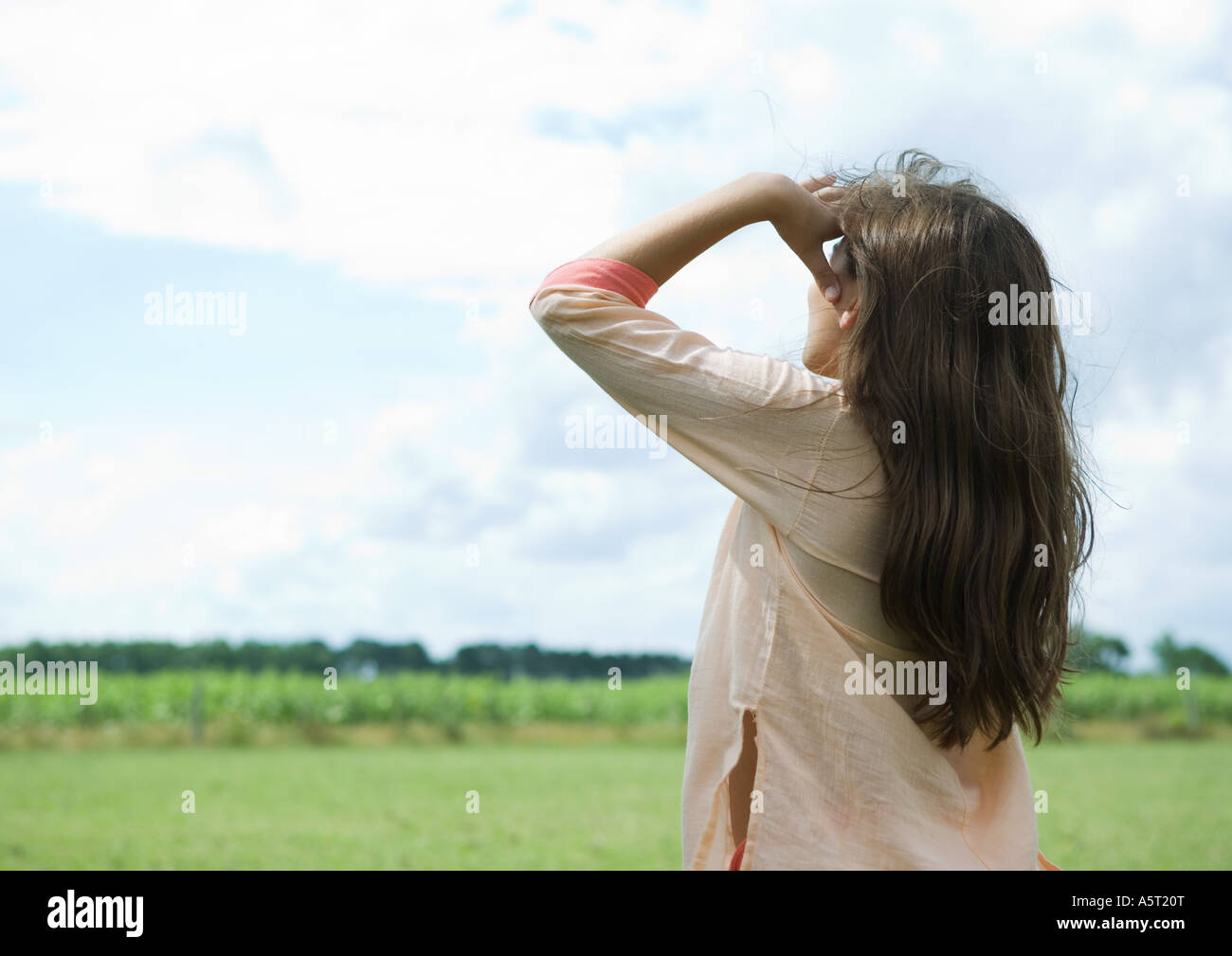 Girl shading eyes, looking toward distance Stock Photo - Alamy