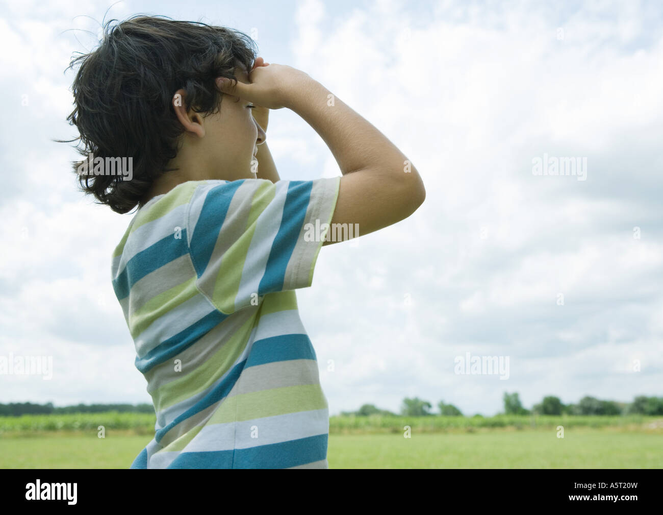 Boy shading eyes looking distance hi-res stock photography and images ...