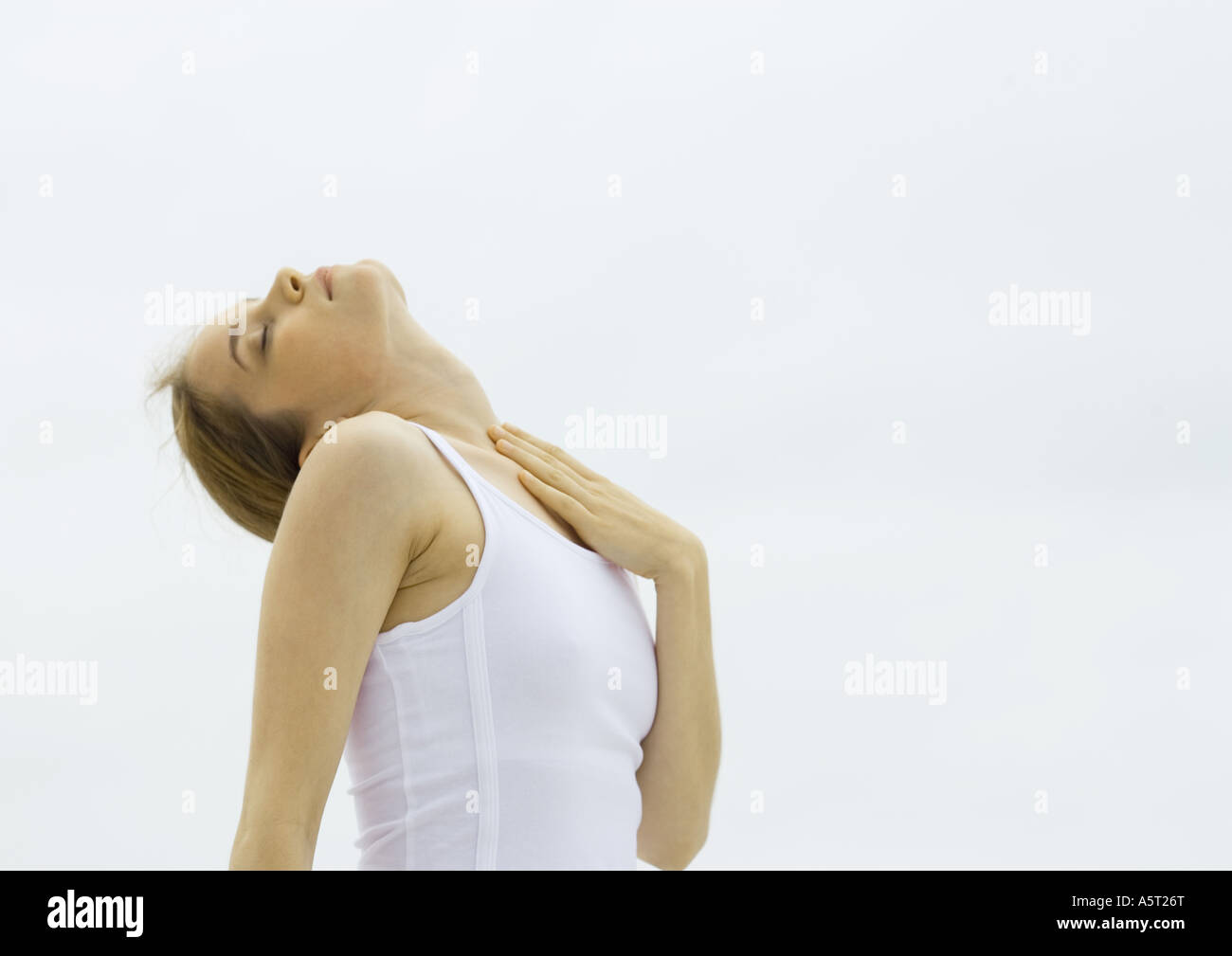 Young woman with head back, touching chest Stock Photo - Alamy