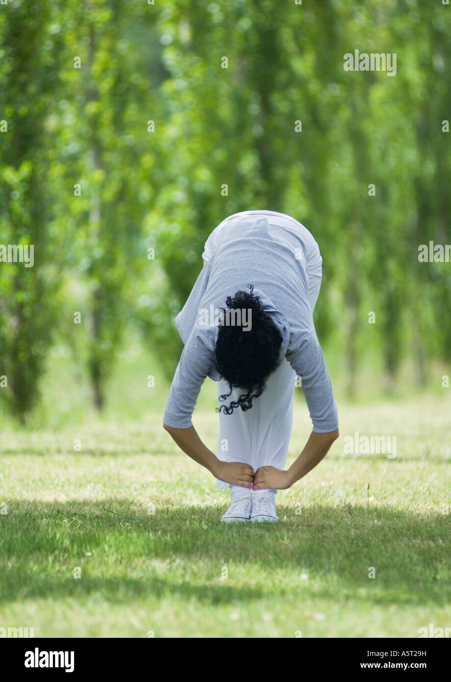 Young woman stretching on grass Stock Photo - Alamy