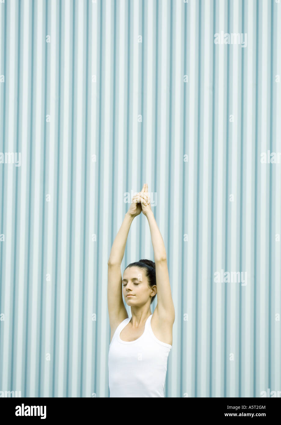 Woman standing with arms overhead, eyes closed Stock Photo - Alamy