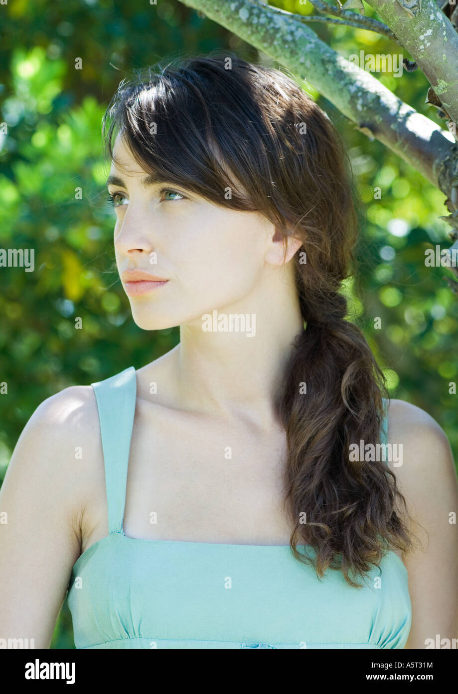 Woman standing under tree, head and shoulders Stock Photo - Alamy