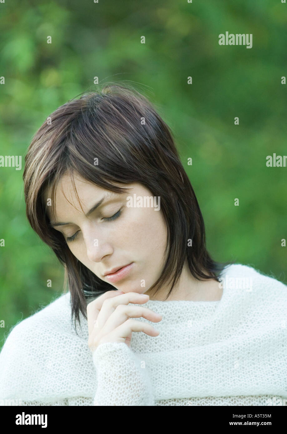 Woman with hand under chin, head and shoulders, eyes closed Stock Photo ...