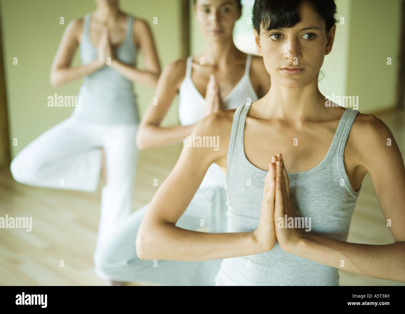 Yoga class doing tree pose Stock Photo - Alamy