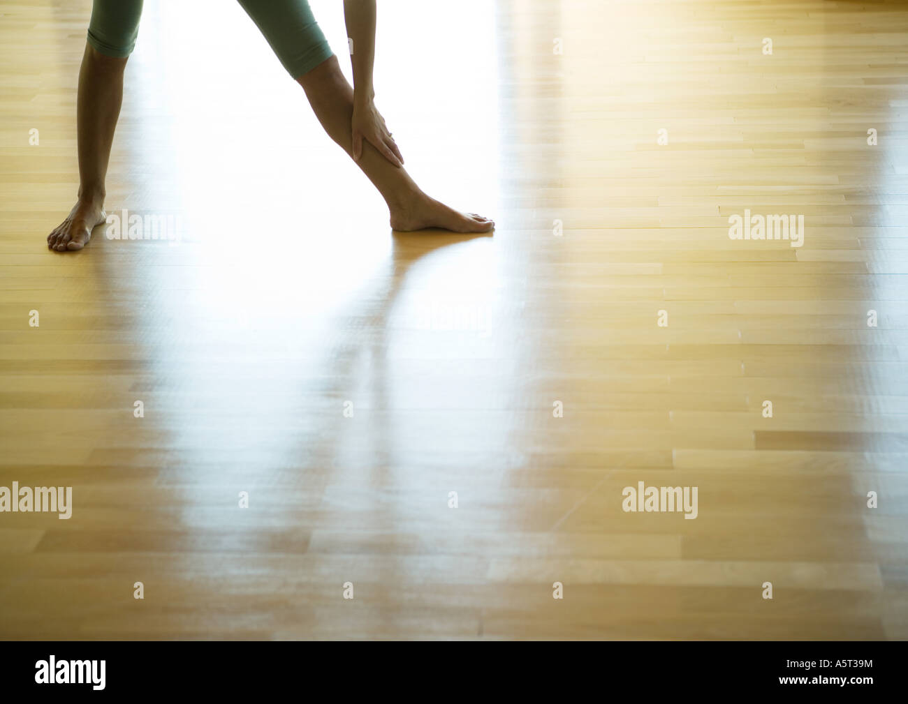 Yoga class, woman standing in triangle position, low section Stock ...