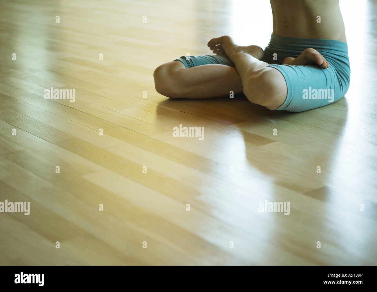 Yoga class, woman sitting in lotus position, waist down Stock Photo - Alamy