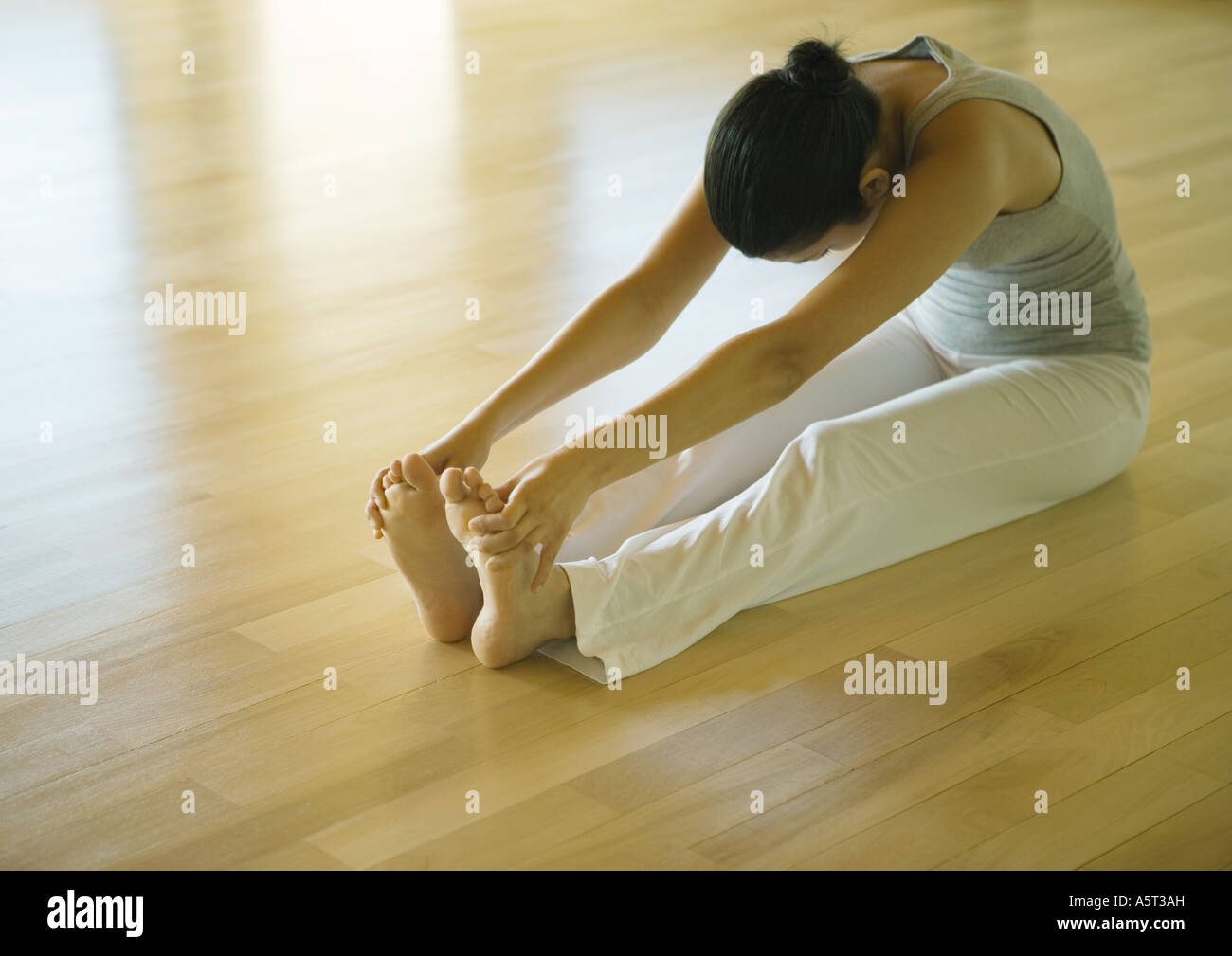 Yoga class, woman doing seated forward bend Stock Photo - Alamy