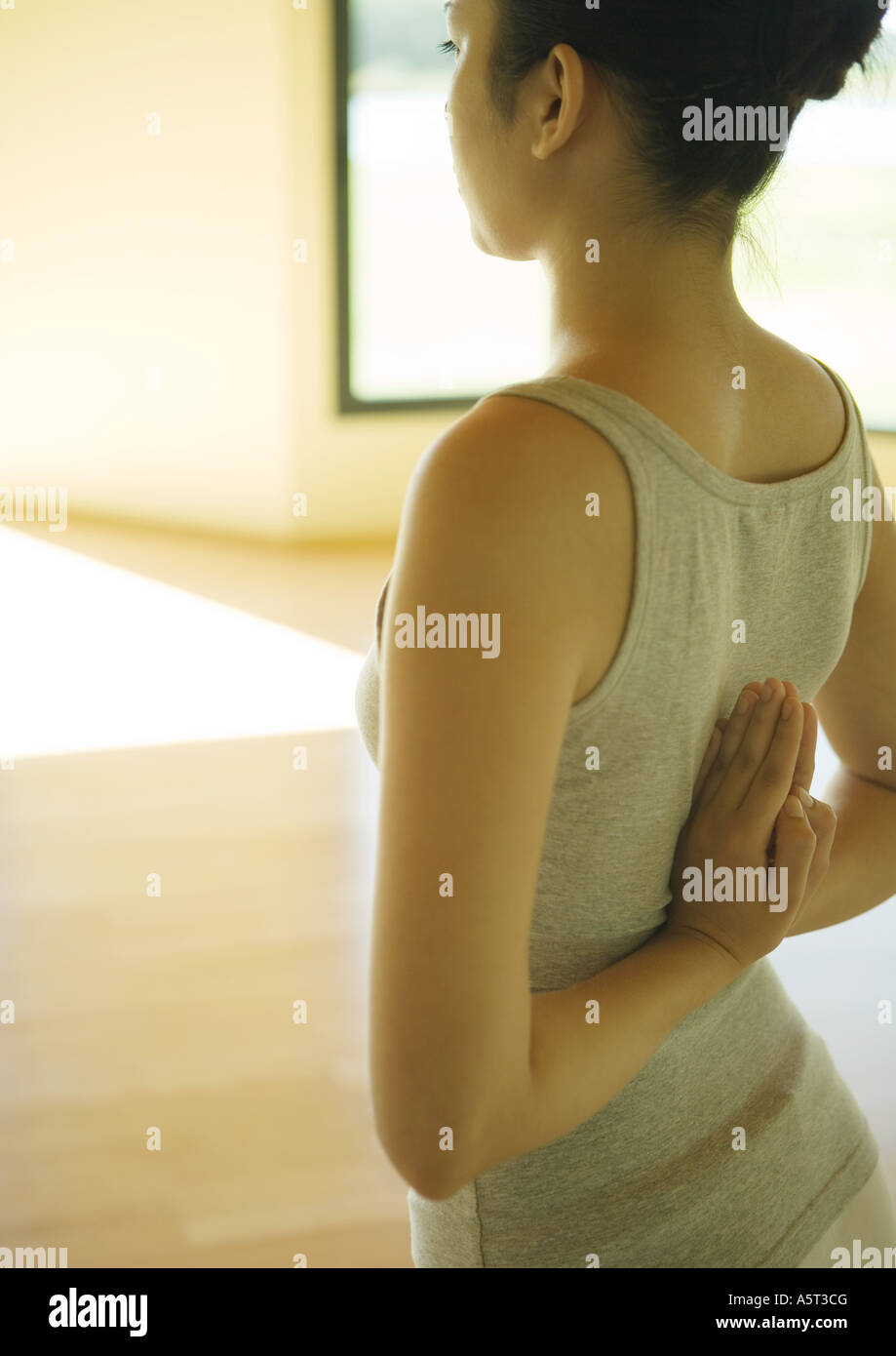 Yoga class, woman standing with hands clasped behind back Stock Photo ...