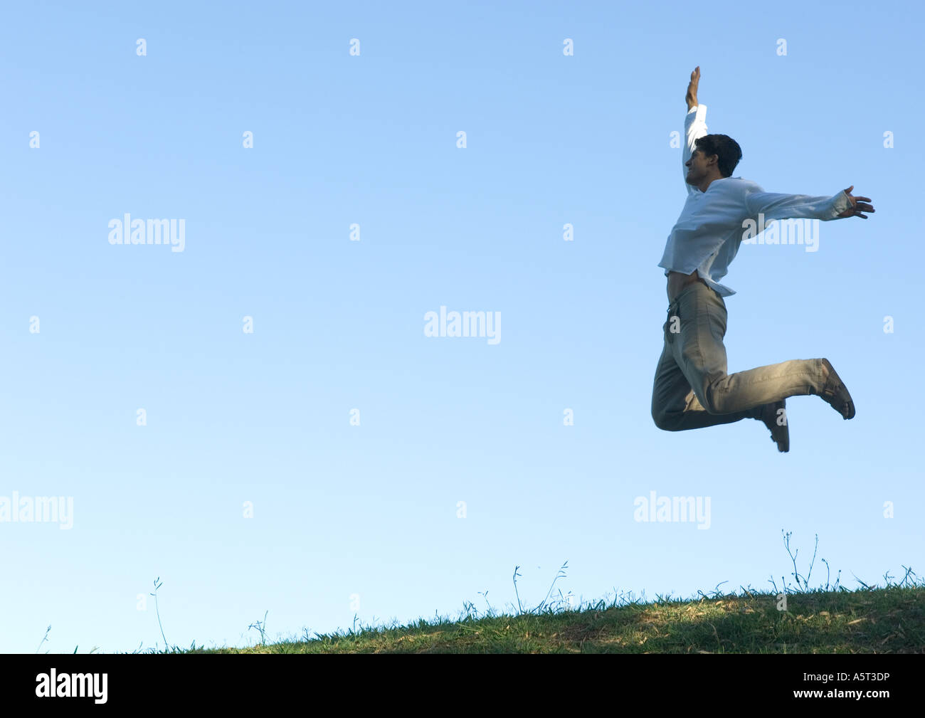 Man jumping in the air, arms out Stock Photo - Alamy