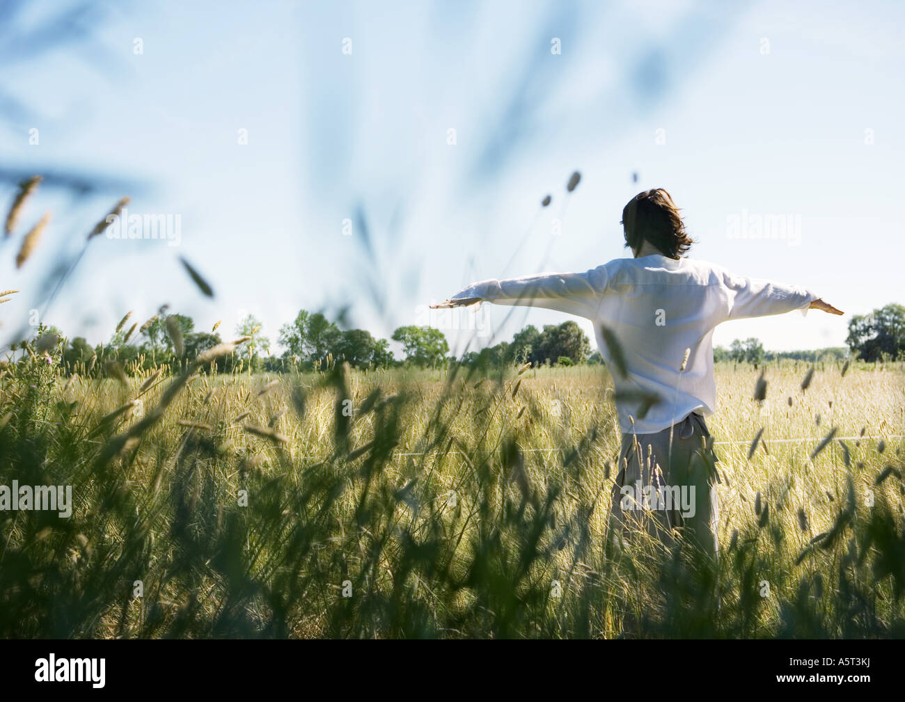 Man standing in field with arms out Stock Photo - Alamy
