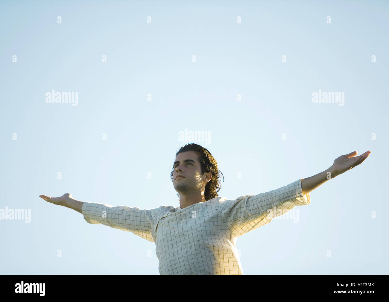Man standing in field with arms out Stock Photo - Alamy