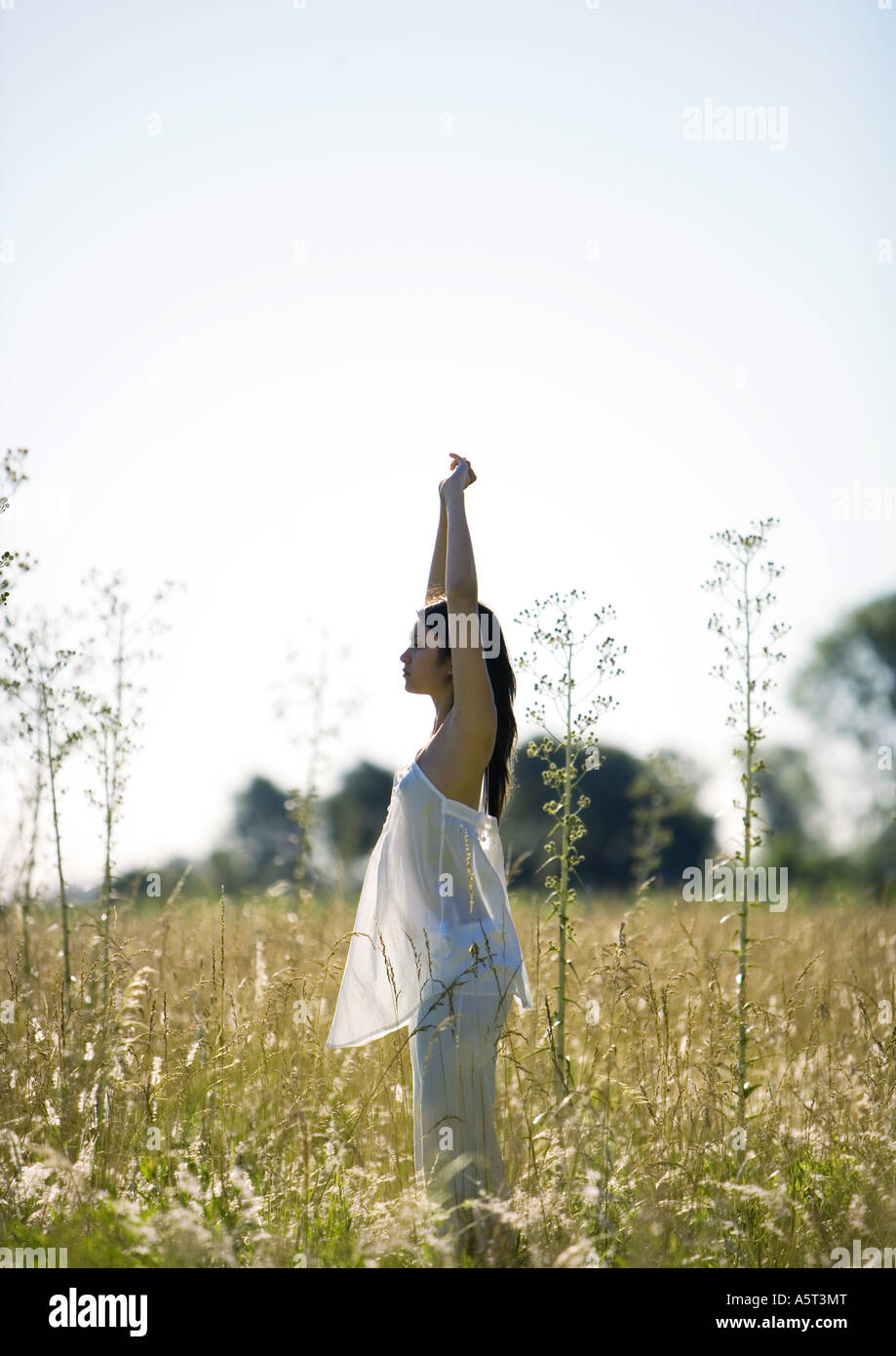 Woman doing sun salutation in field Stock Photo - Alamy
