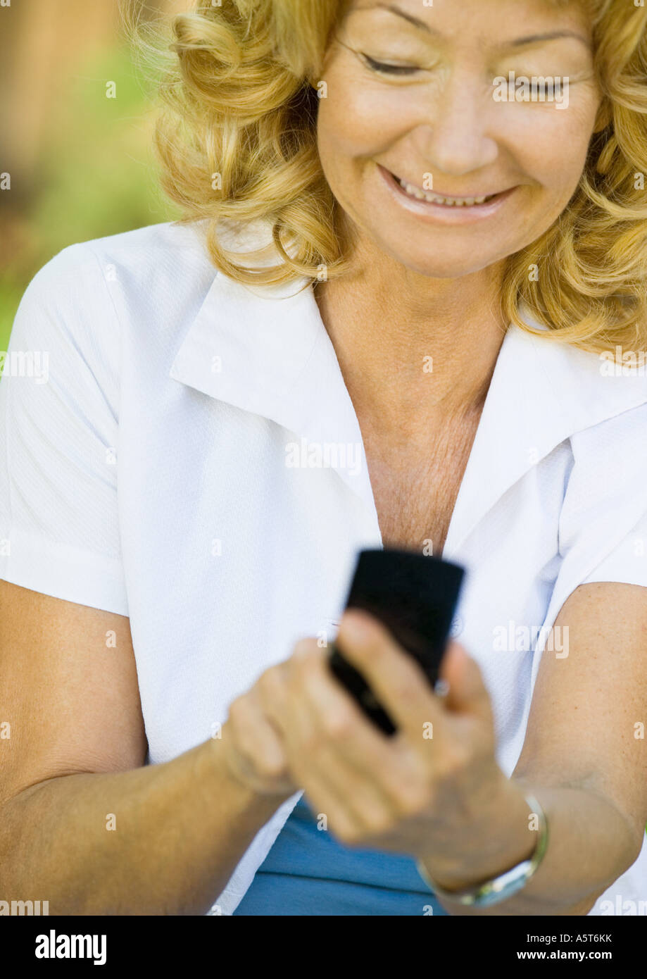Senior woman dialing cell phone, smiling Stock Photo - Alamy