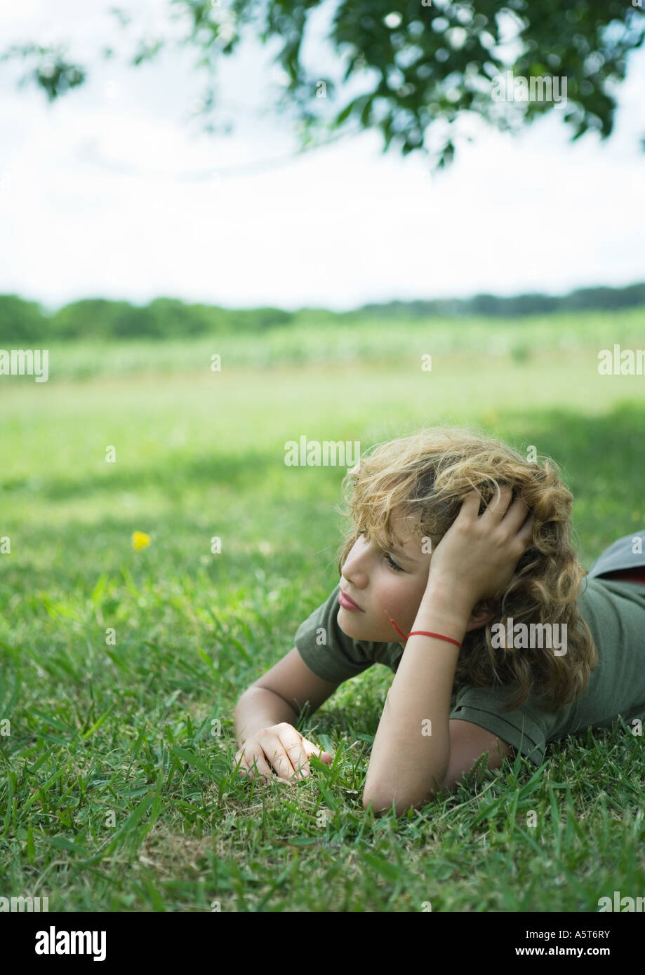Boy lying in grass Stock Photo - Alamy