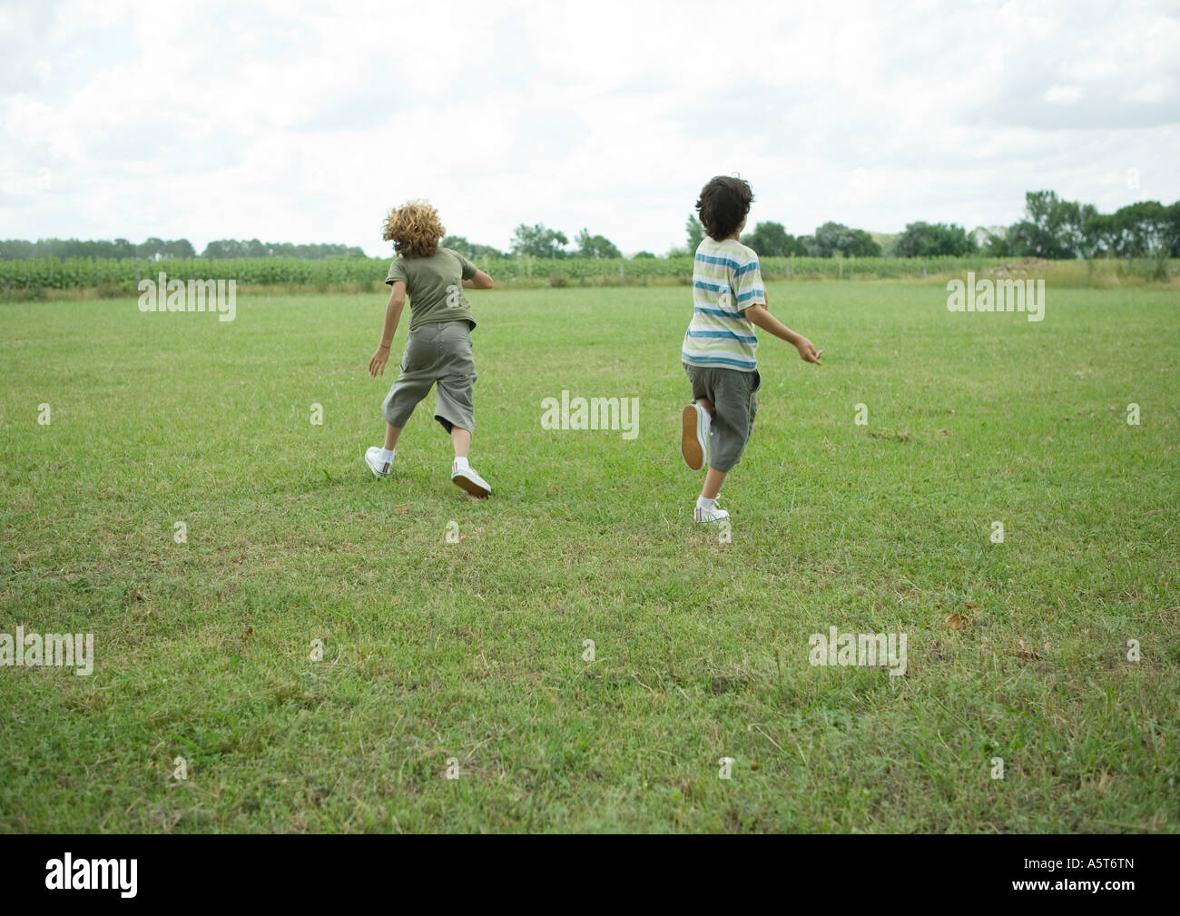 Boys running in field Stock Photo - Alamy