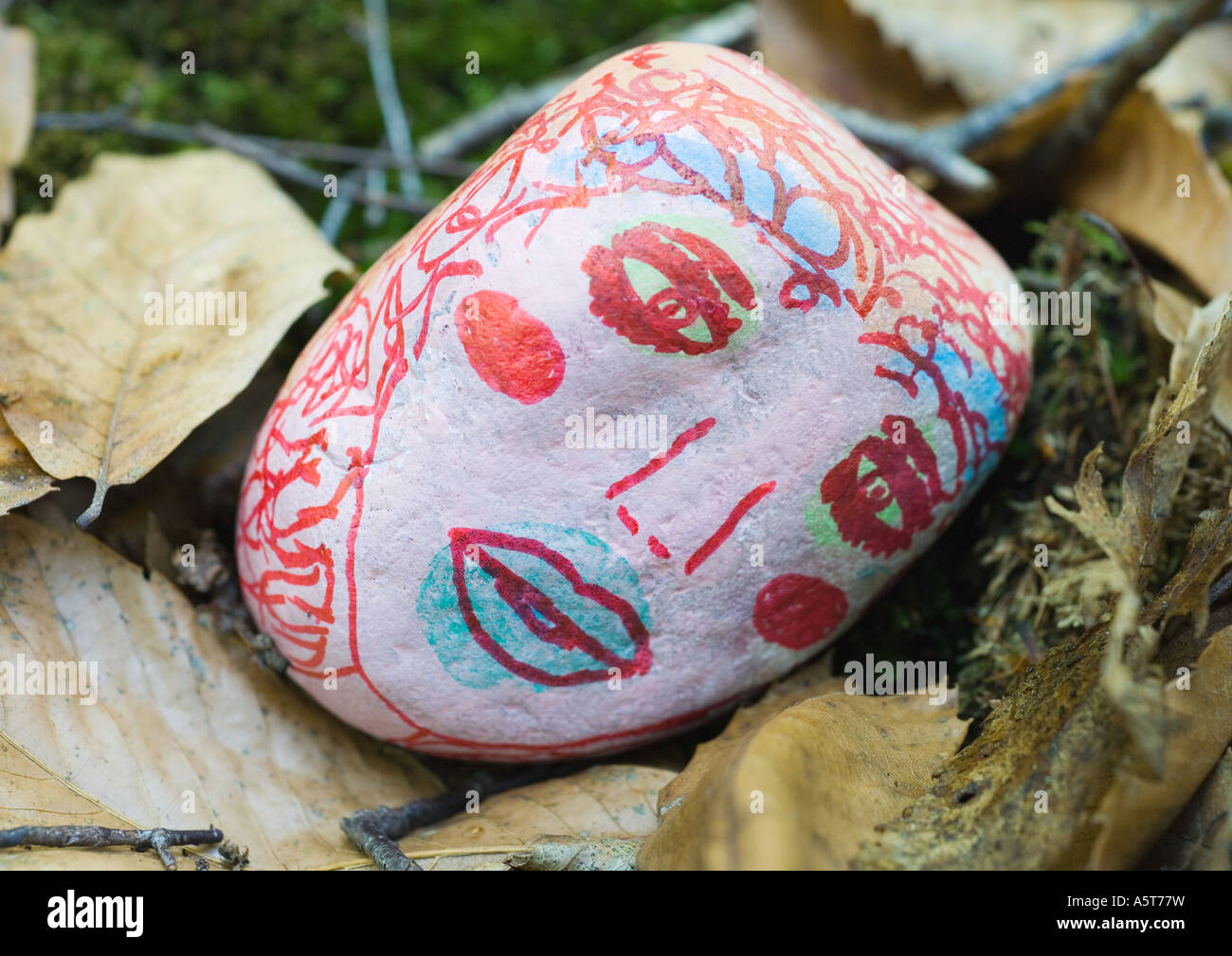 Stone decorated with face, lying on ground Stock Photo - Alamy