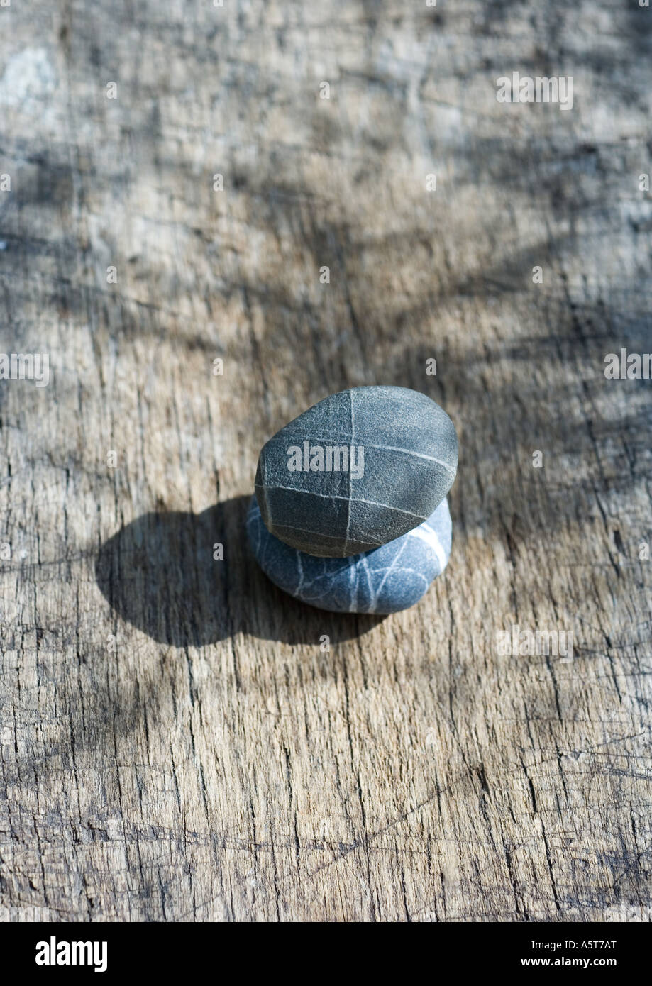 Stacked pebbles on wood Stock Photo - Alamy