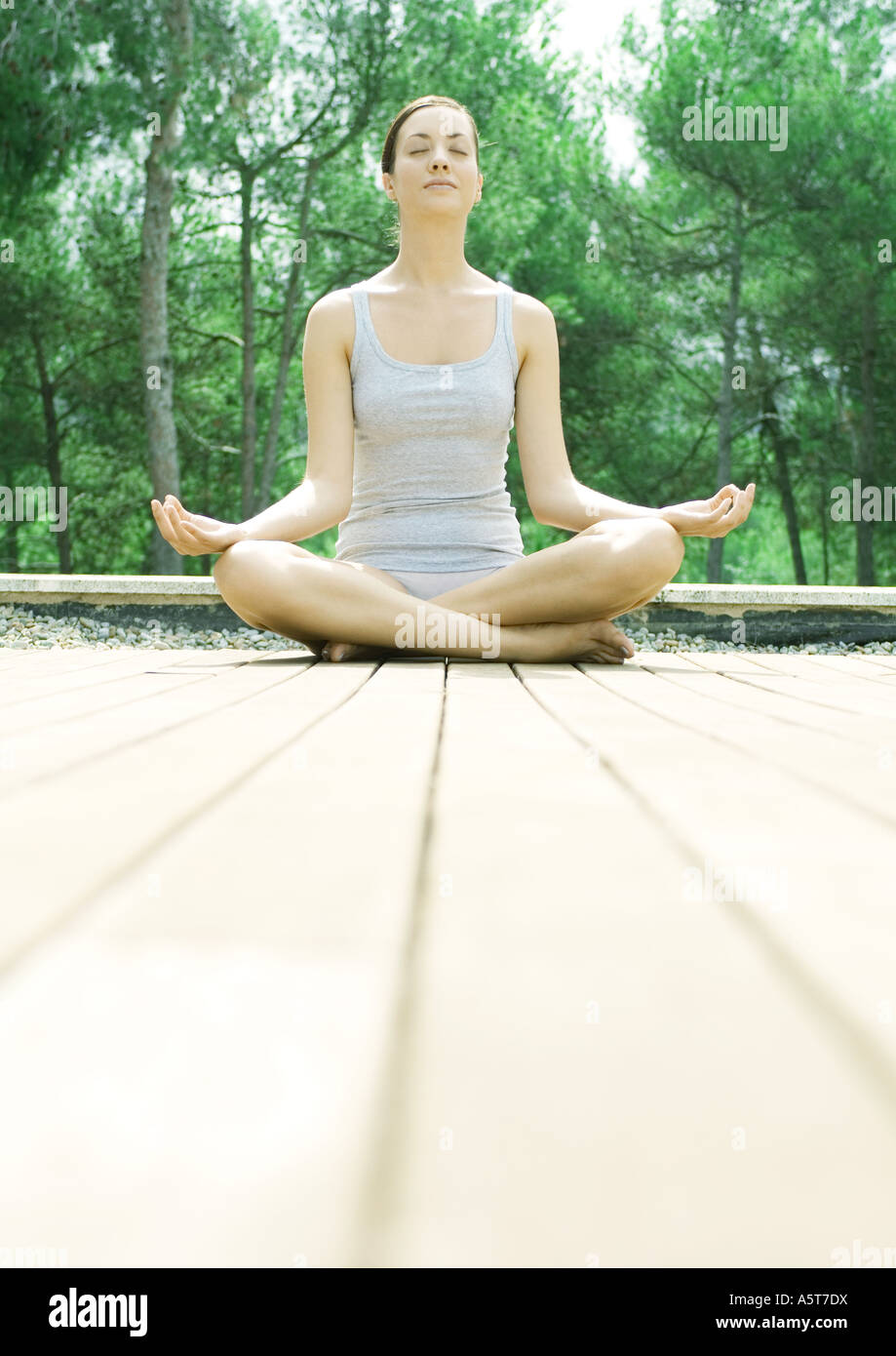 Woman sitting on deck, in lotus position Stock Photo - Alamy