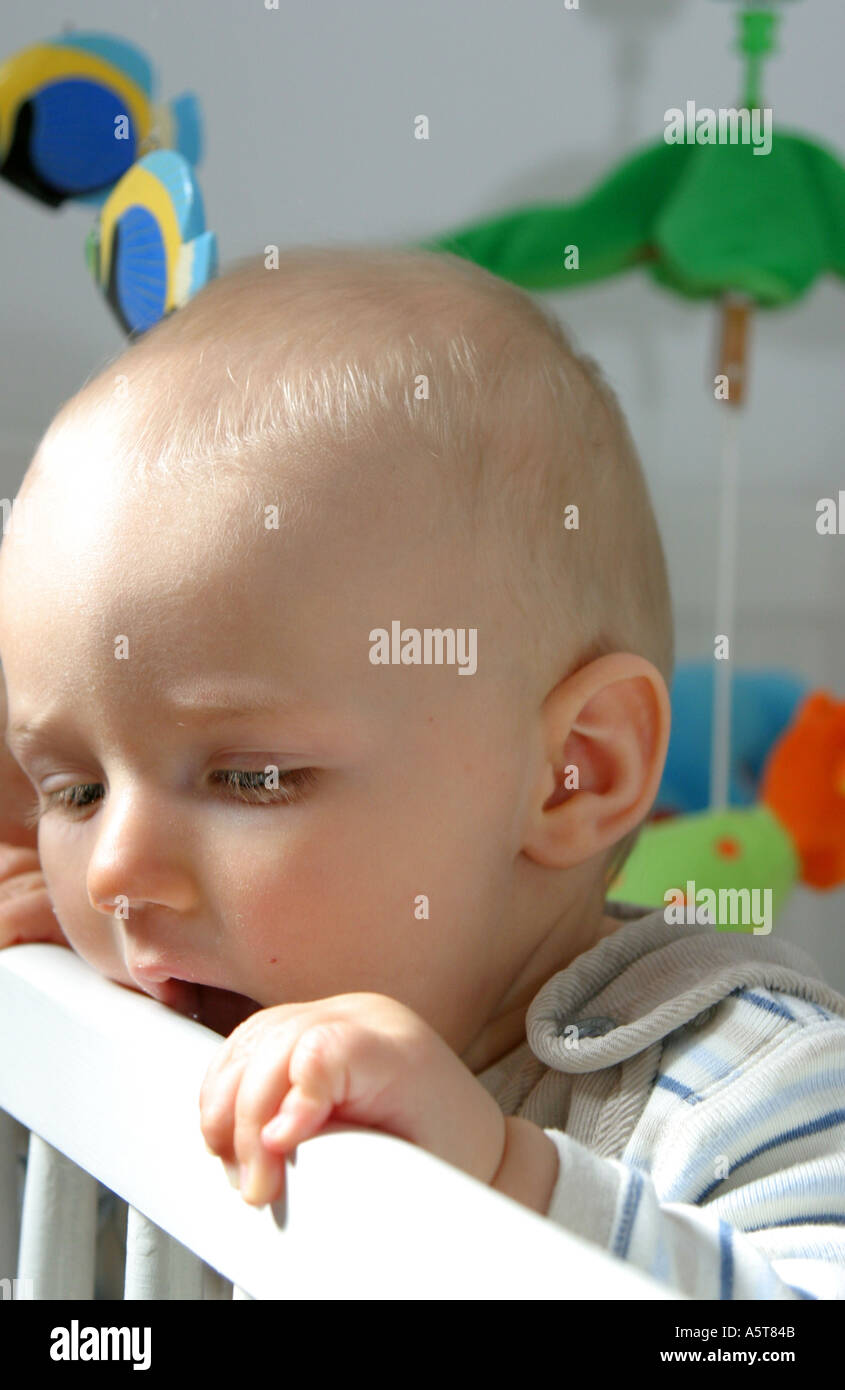 baby boy peering over cot Stock Photo - Alamy