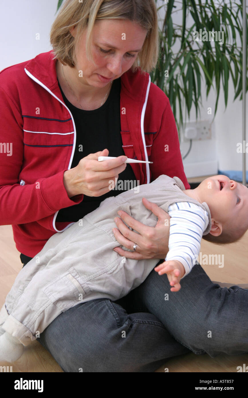 mother checking temperature of baby boy Stock Photo - Alamy