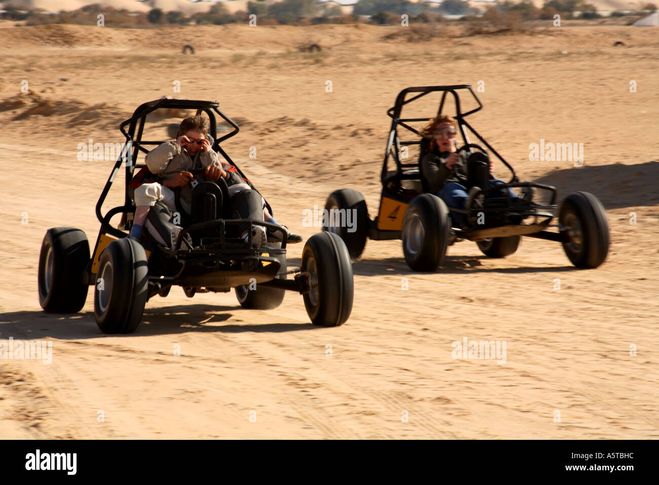Horizontal portrait of children in go karts near Douz, Sahara desert ...
