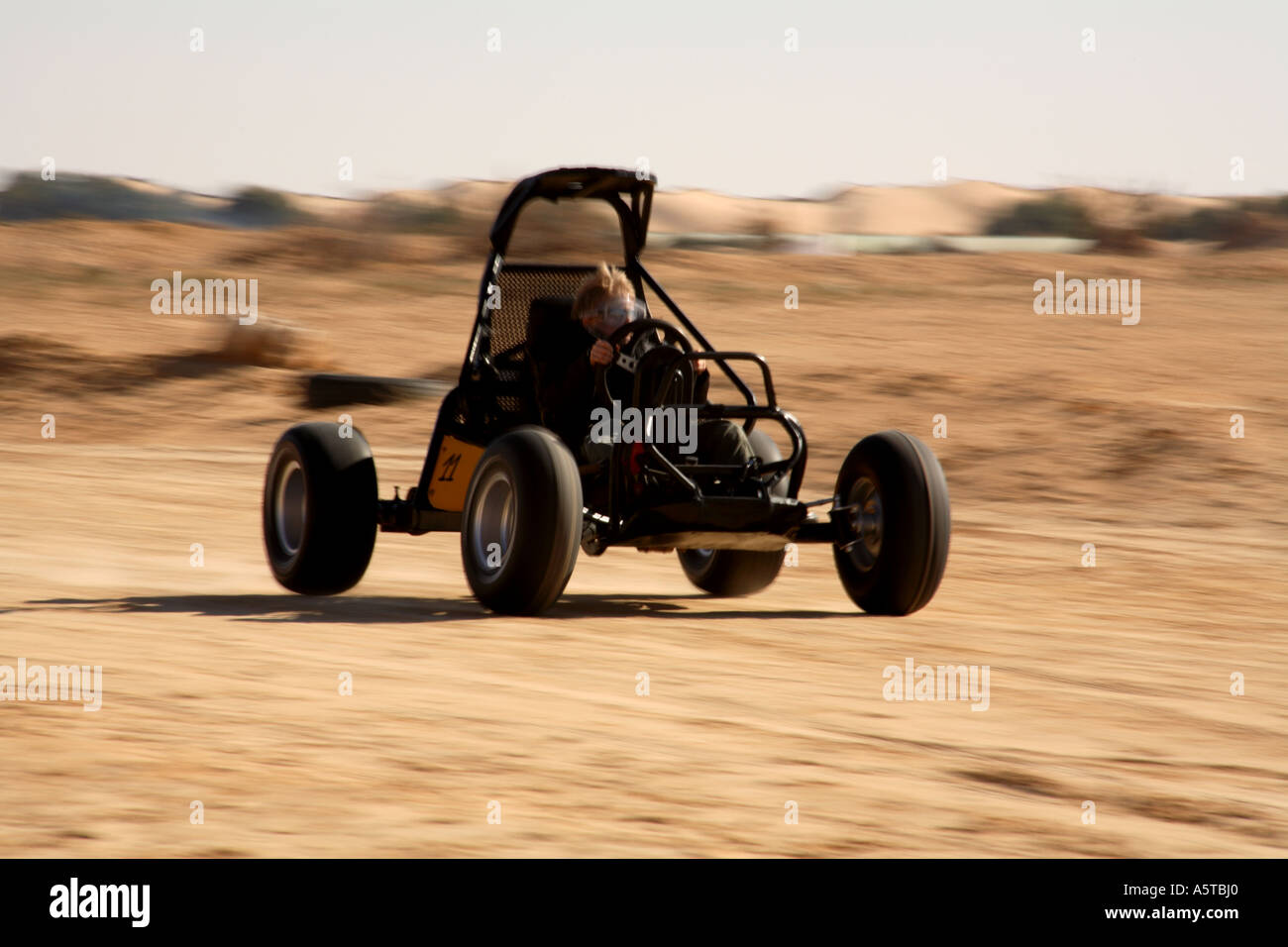 Panned horizontal portrait of boy in go kart driving at speed, showing ...