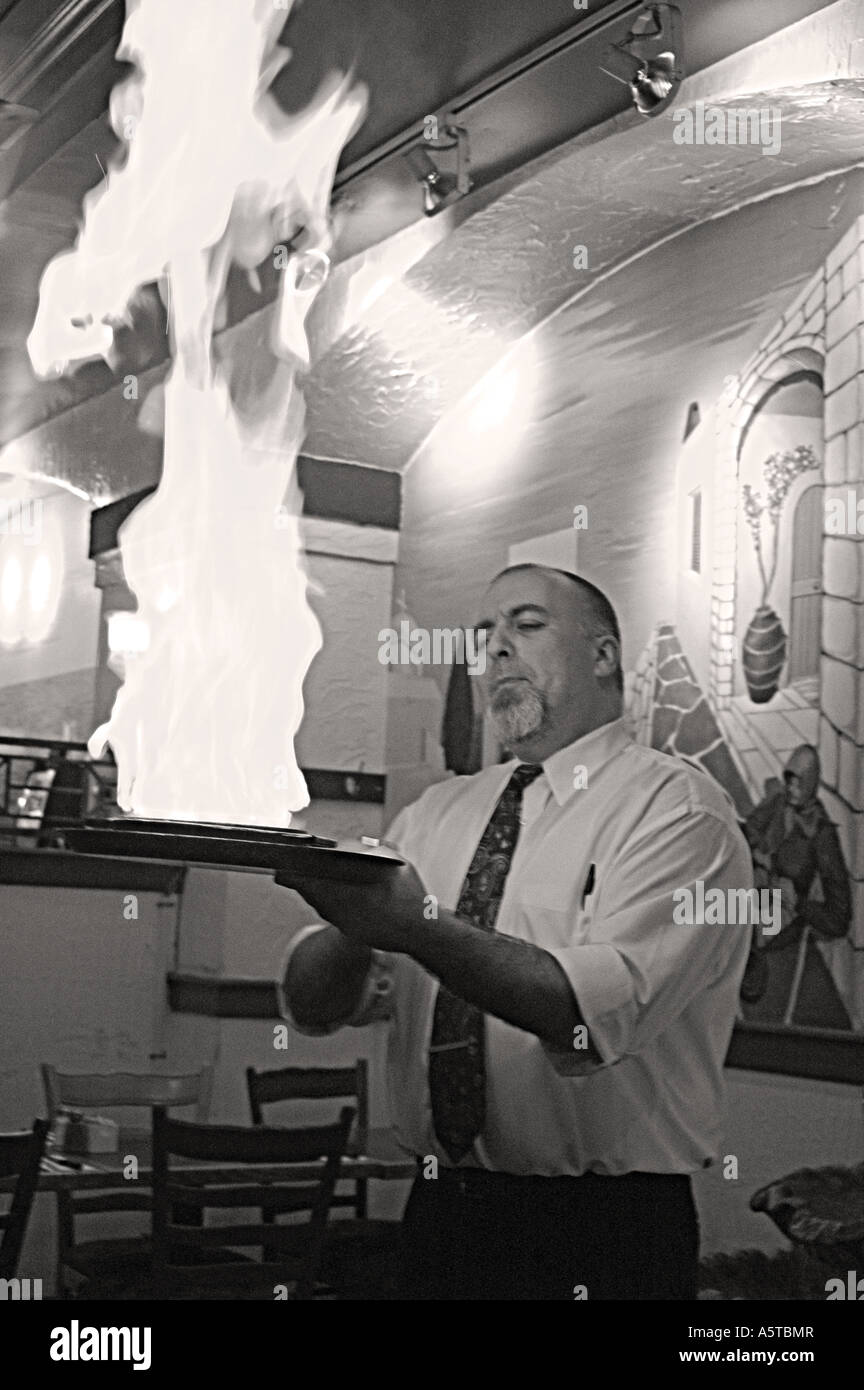 Waiter Serving Greek Flaming Cheese dish (Saganaki Stock Photo - Alamy