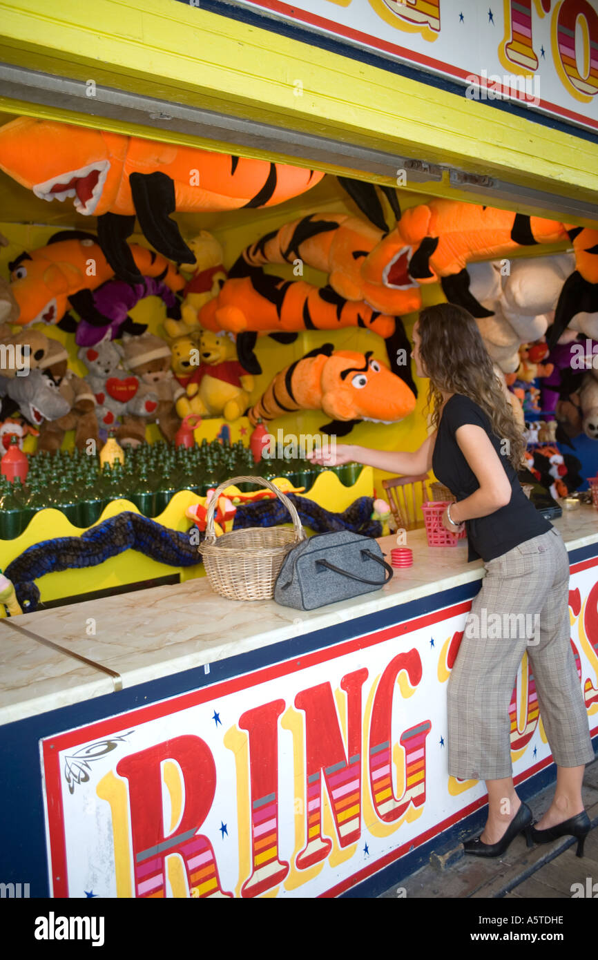 Pretty girl throwing hoops on a stall at the fun fair on South Pier ...