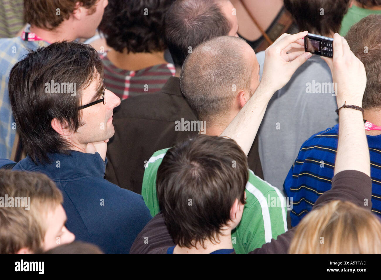 Man taking photograph with mobile phone in concert crowd Stock Photo ...