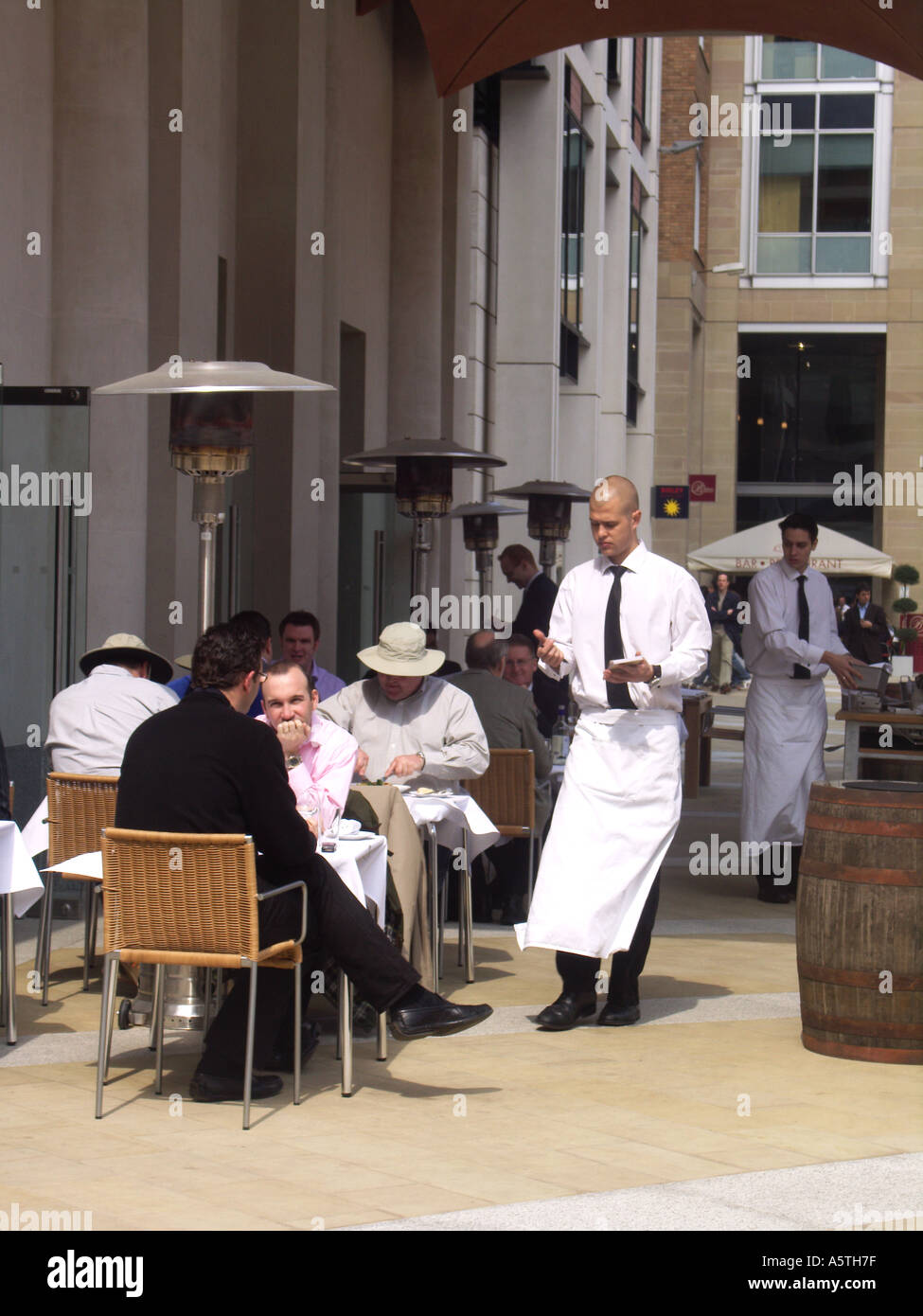 Waiter serving diners eating outside restaurant Paternoster Square ...