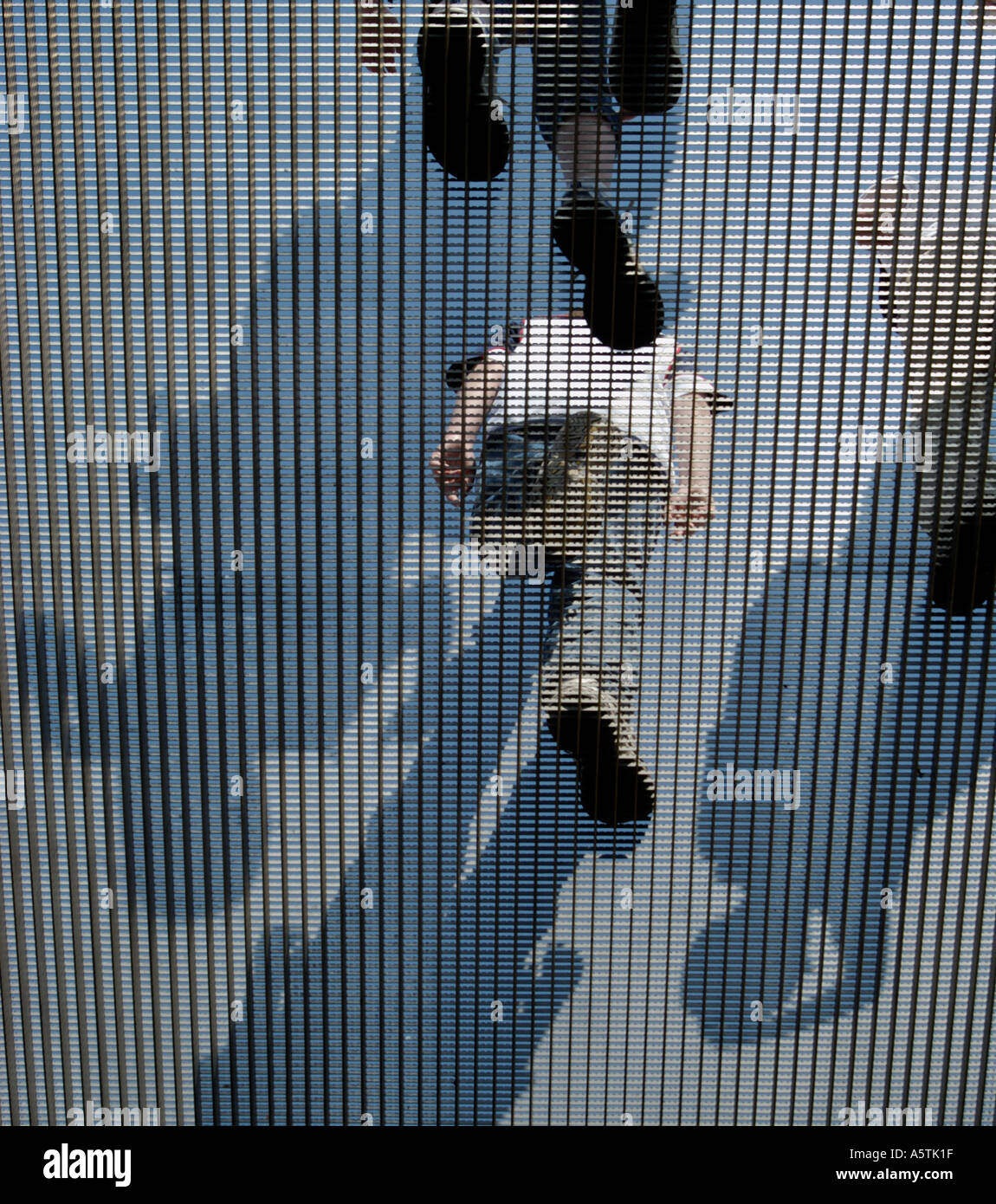 Looking up through grid in a pedestrian walkway at people walking ...