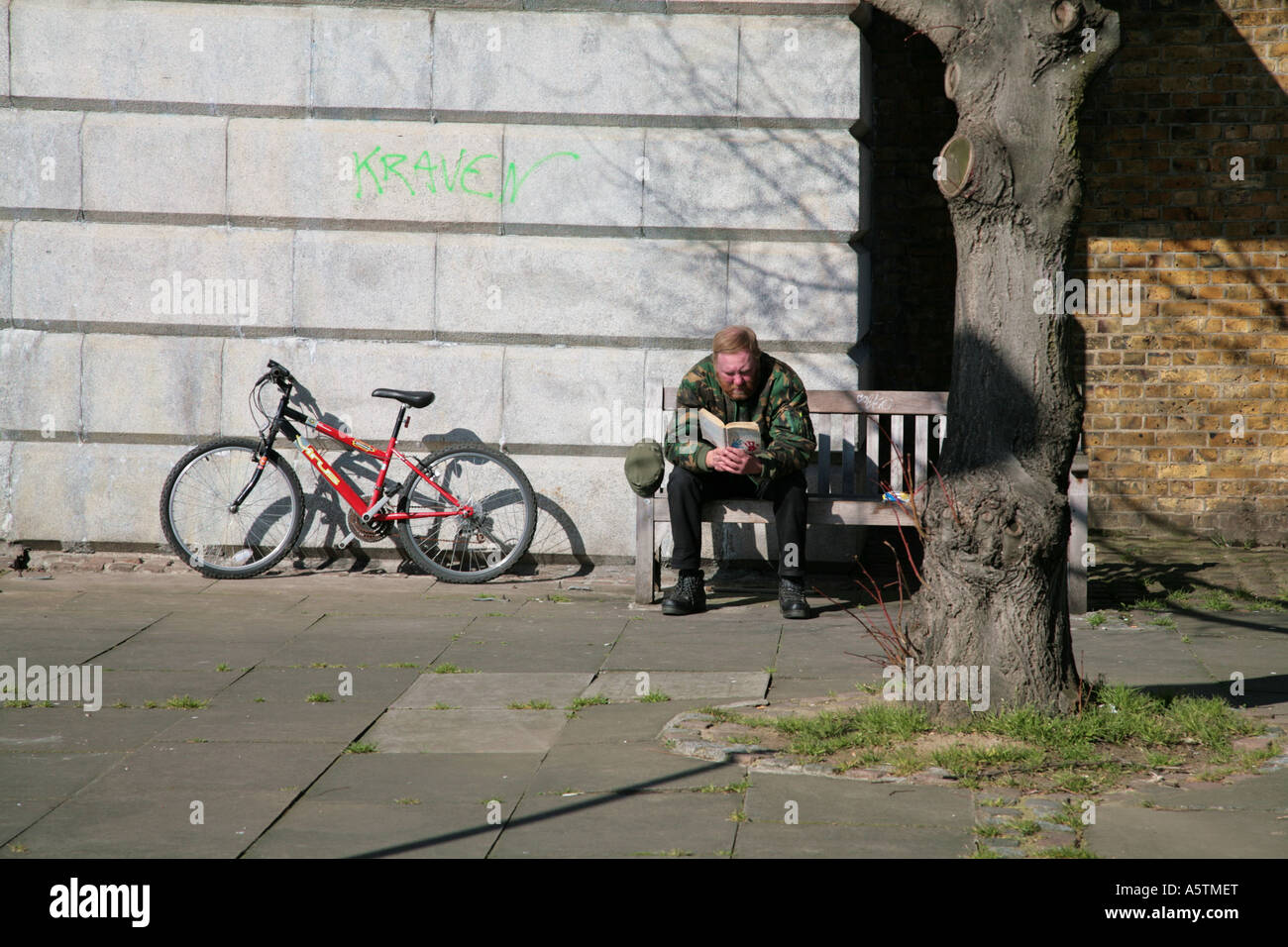man sat on bench reading Stock Photo - Alamy