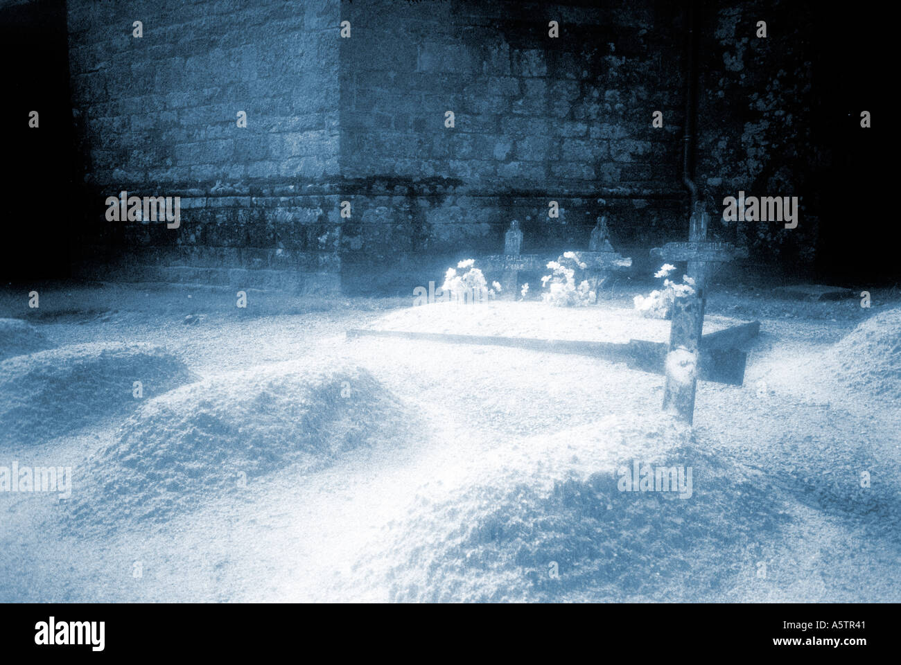burial mounds by church wall in Brittany Stock Photo - Alamy