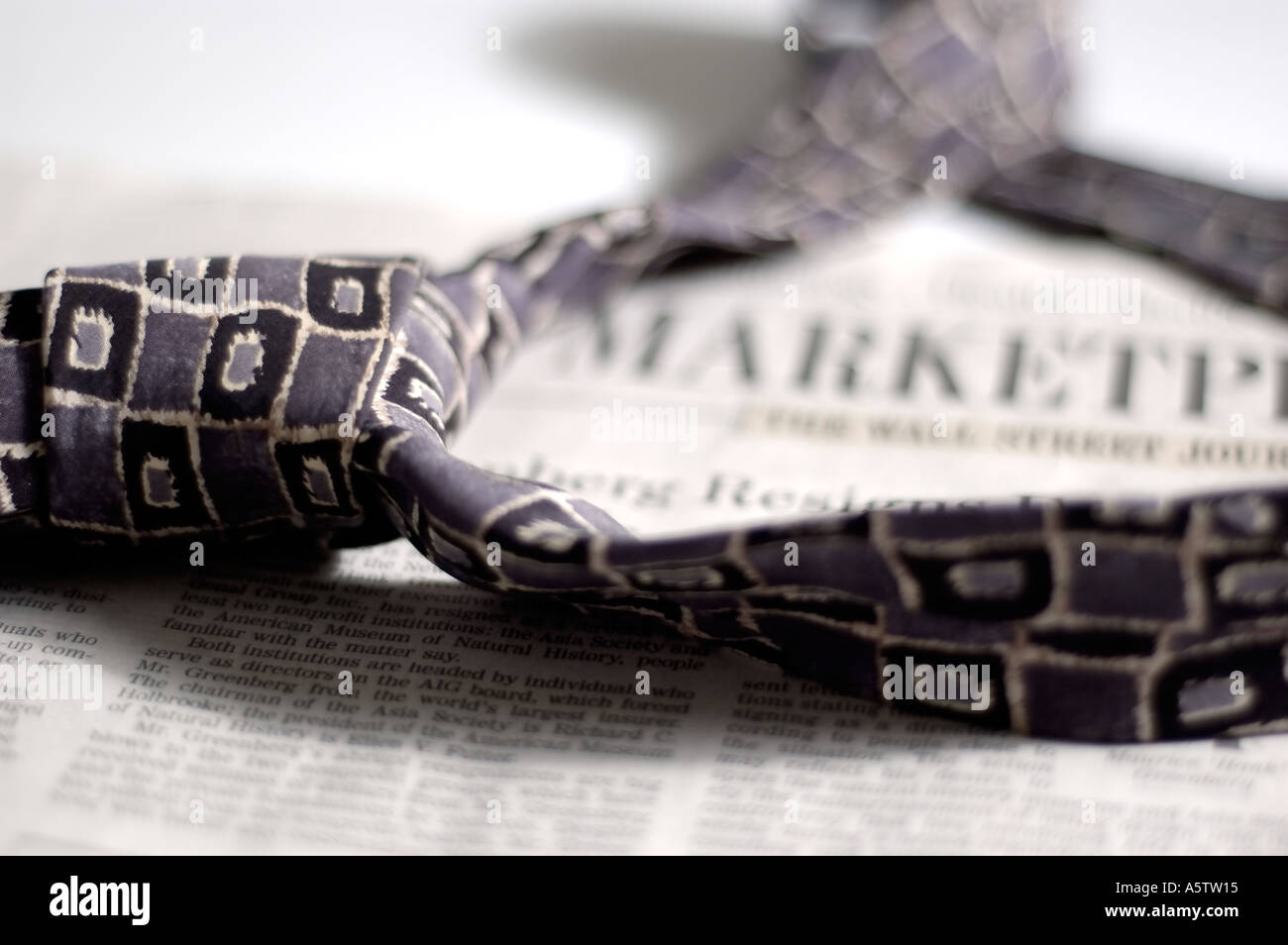 Grey silk tie with knot on top of newspaper business section Stock ...
