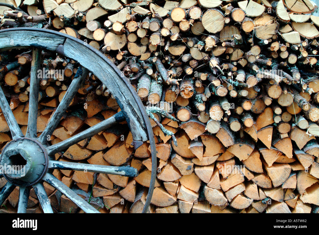pile of wood with an old cartwheel Stock Photo - Alamy