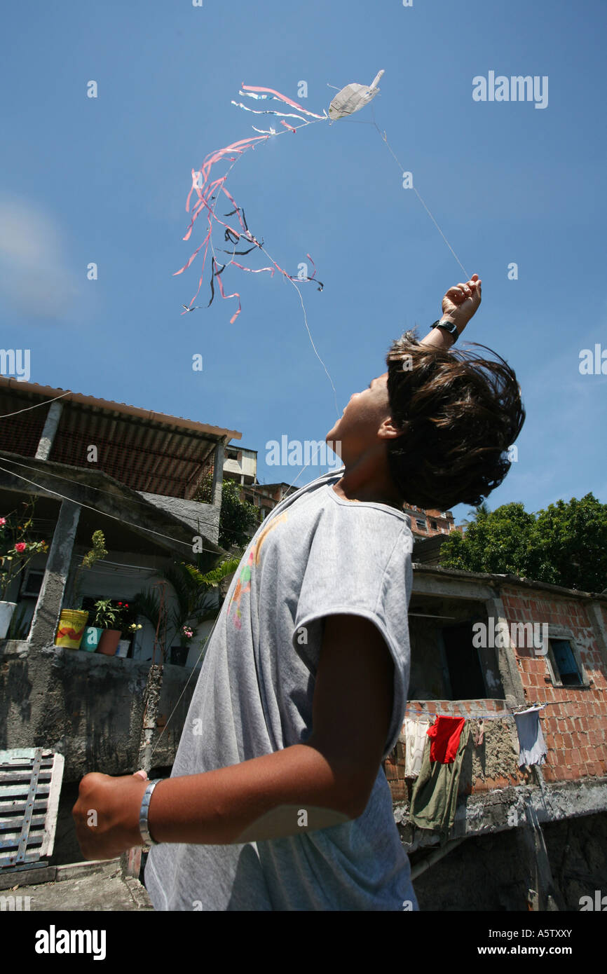 Portrait of young boy flying his kite over shantytown favela, Rio de ...