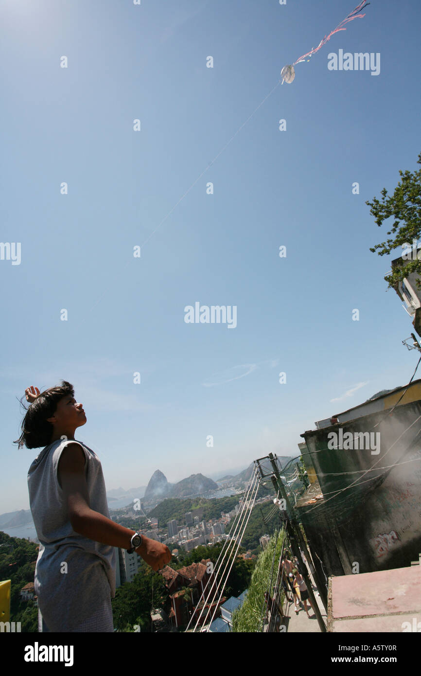 Portrait of young boy flying his kite over shantytown favela, Rio de ...