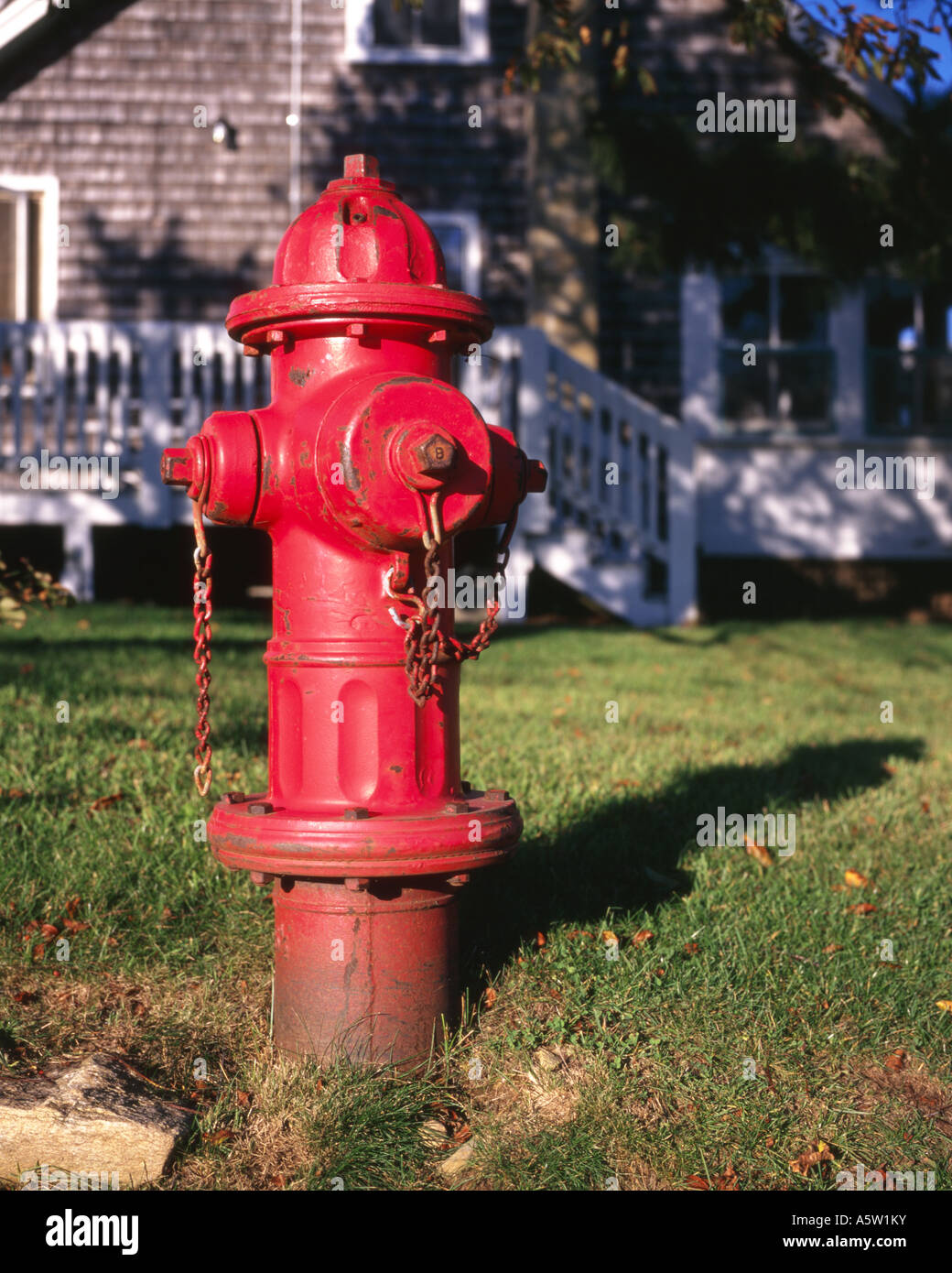 Red fire hydrant in the front garden of clapboard house hi-res stock ...