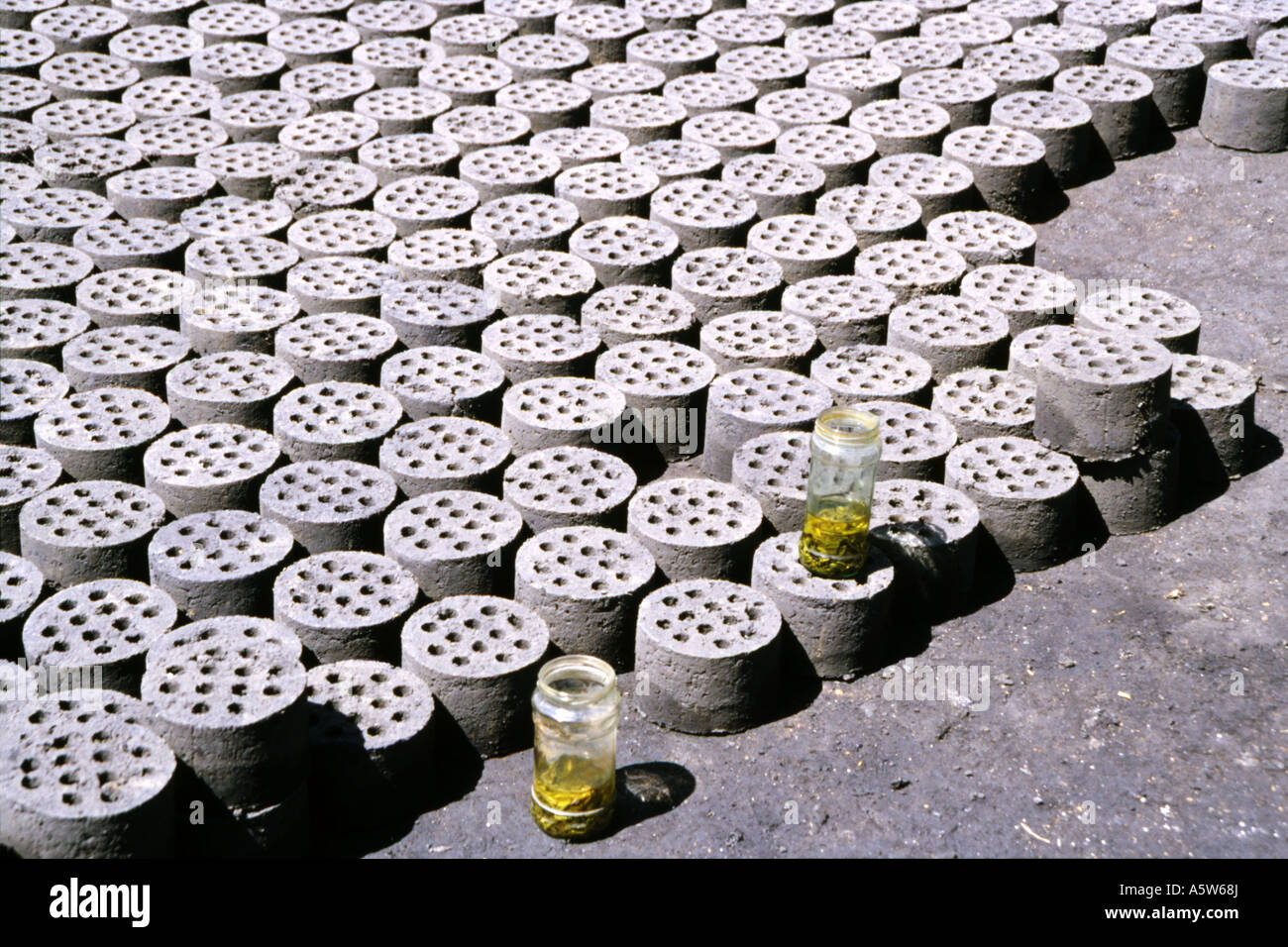 Solid fuel briquettes,workers jam jars of tea on top,drying in the sun ...