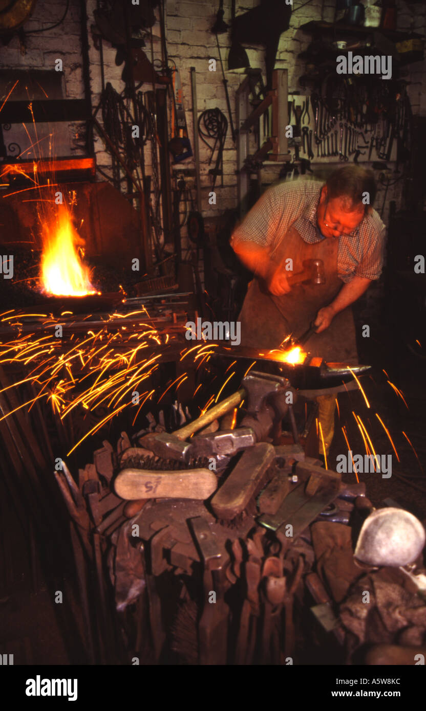Male blacksmith hammering metalwork hi-res stock photography and images ...