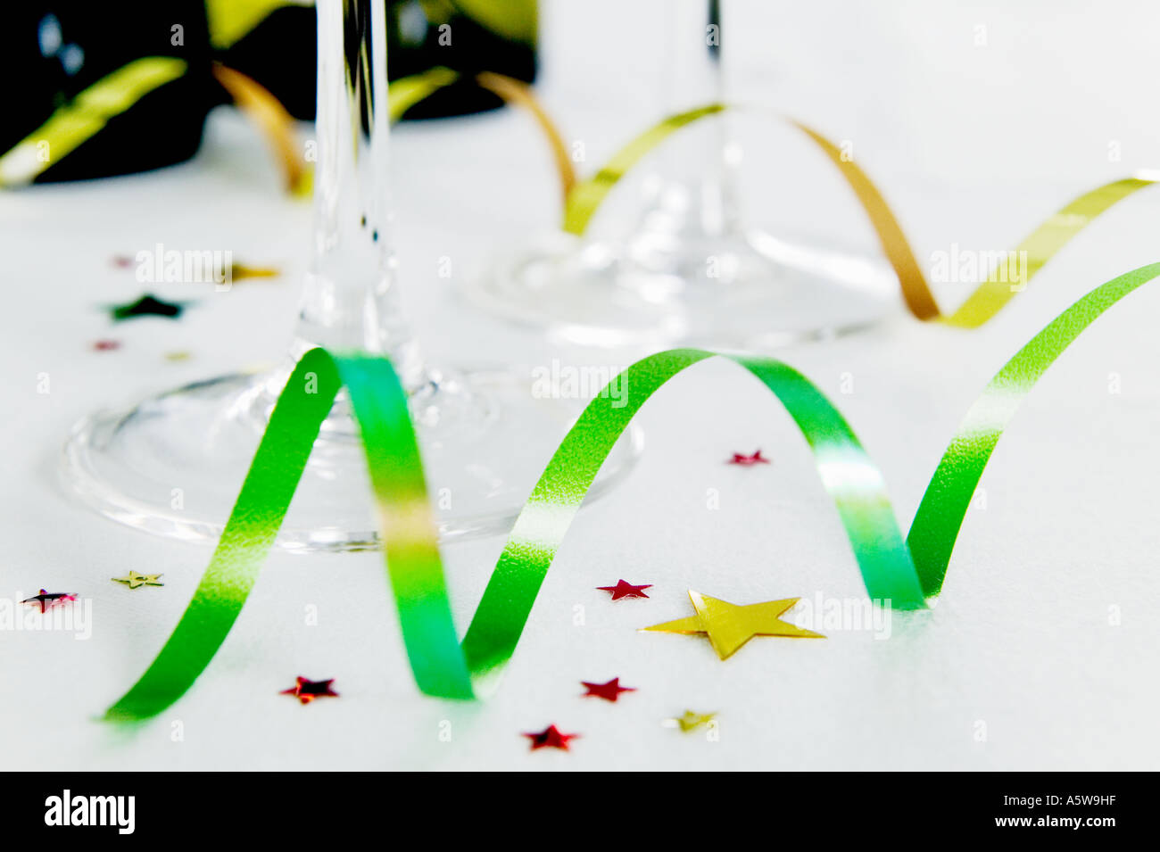 Streamers green and gold on table with star confetti and champagne wine ...