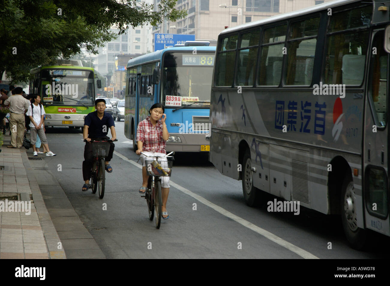 China Beijing Bikers And Buses In A Street Downtown Stock Photo - Alamy